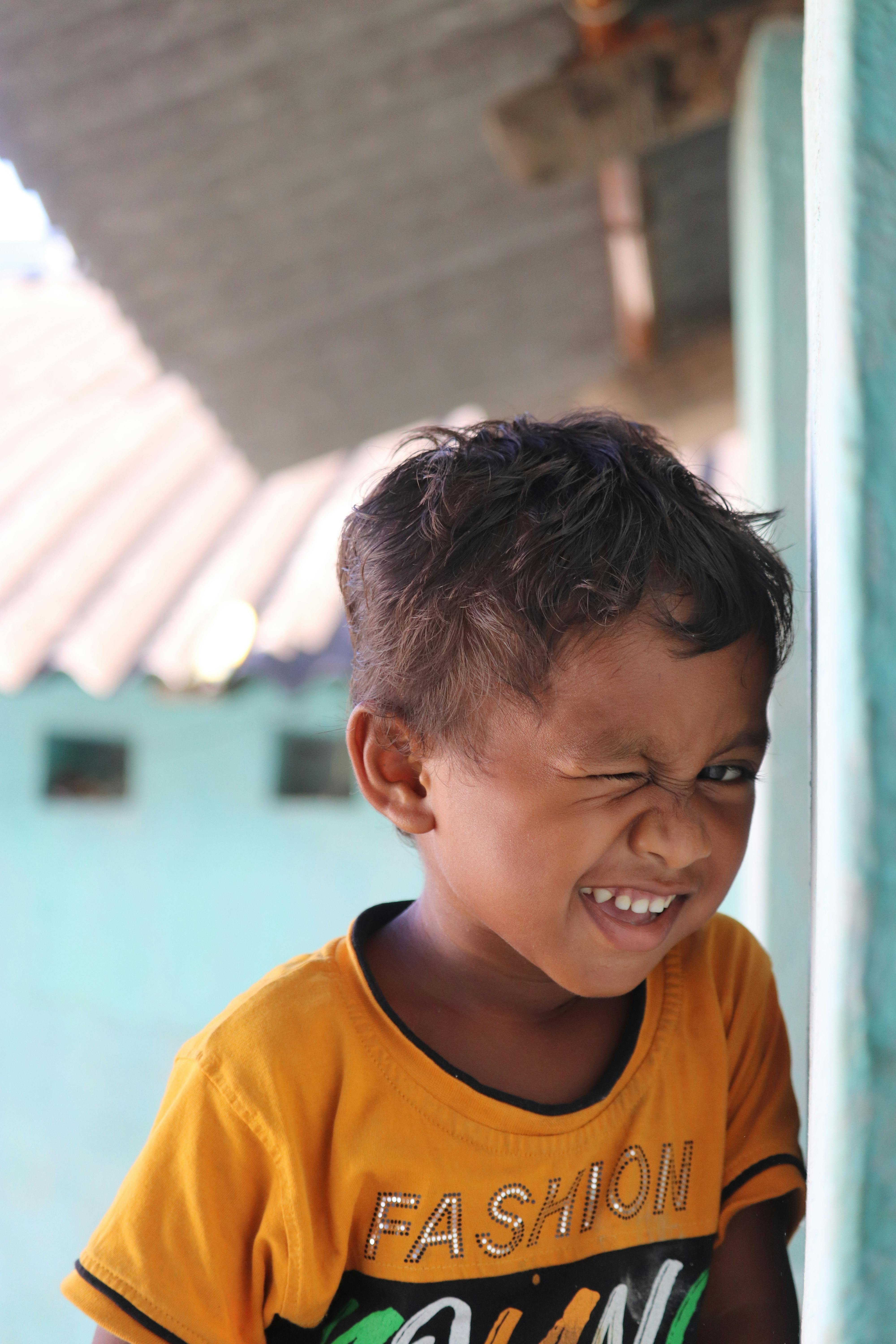 Smiling Child Winking in Vibrant Outdoor Setting · Free Stock Photo