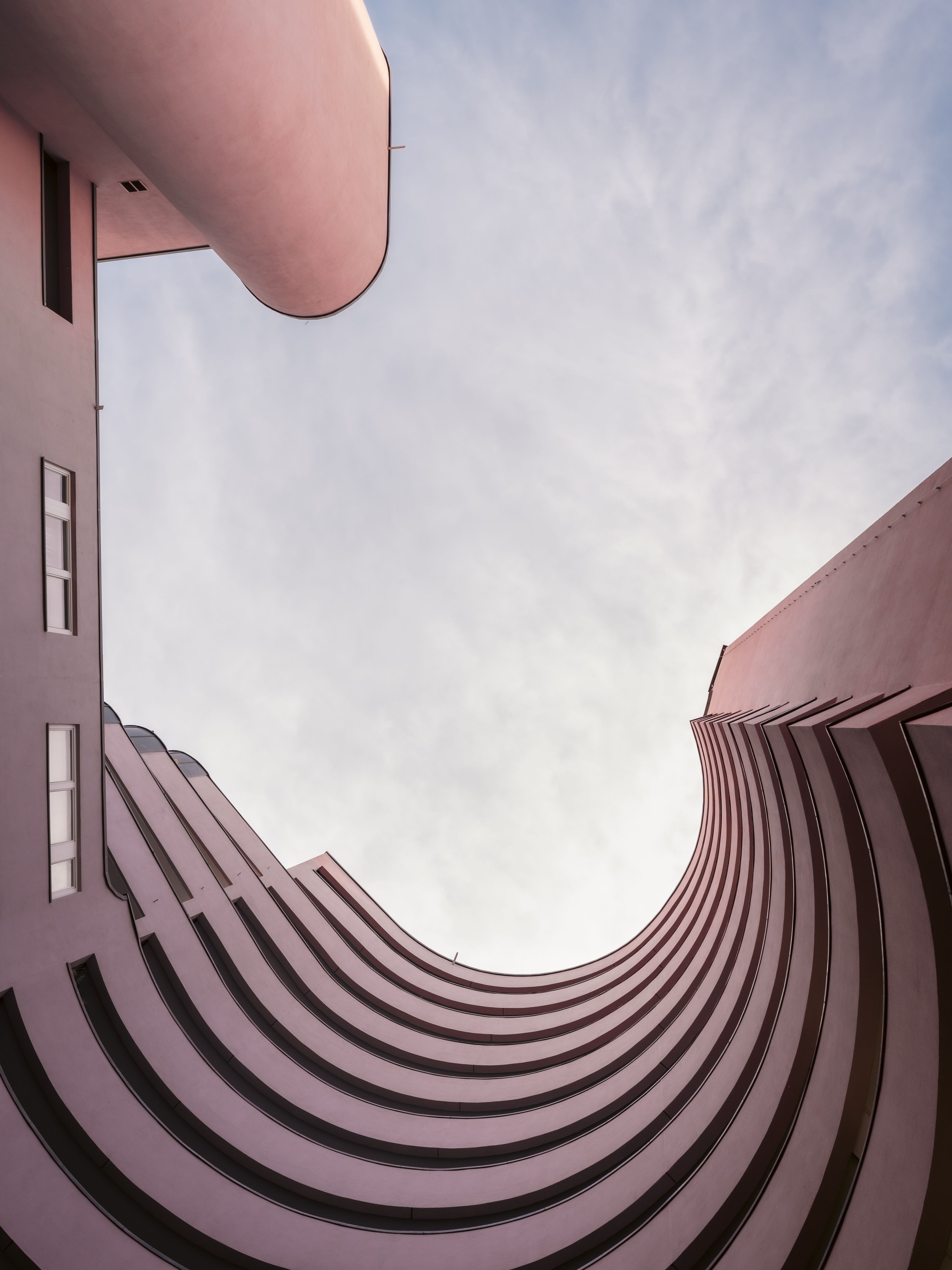 Curved Modern Building Against Blue Sky · Free Stock Photo