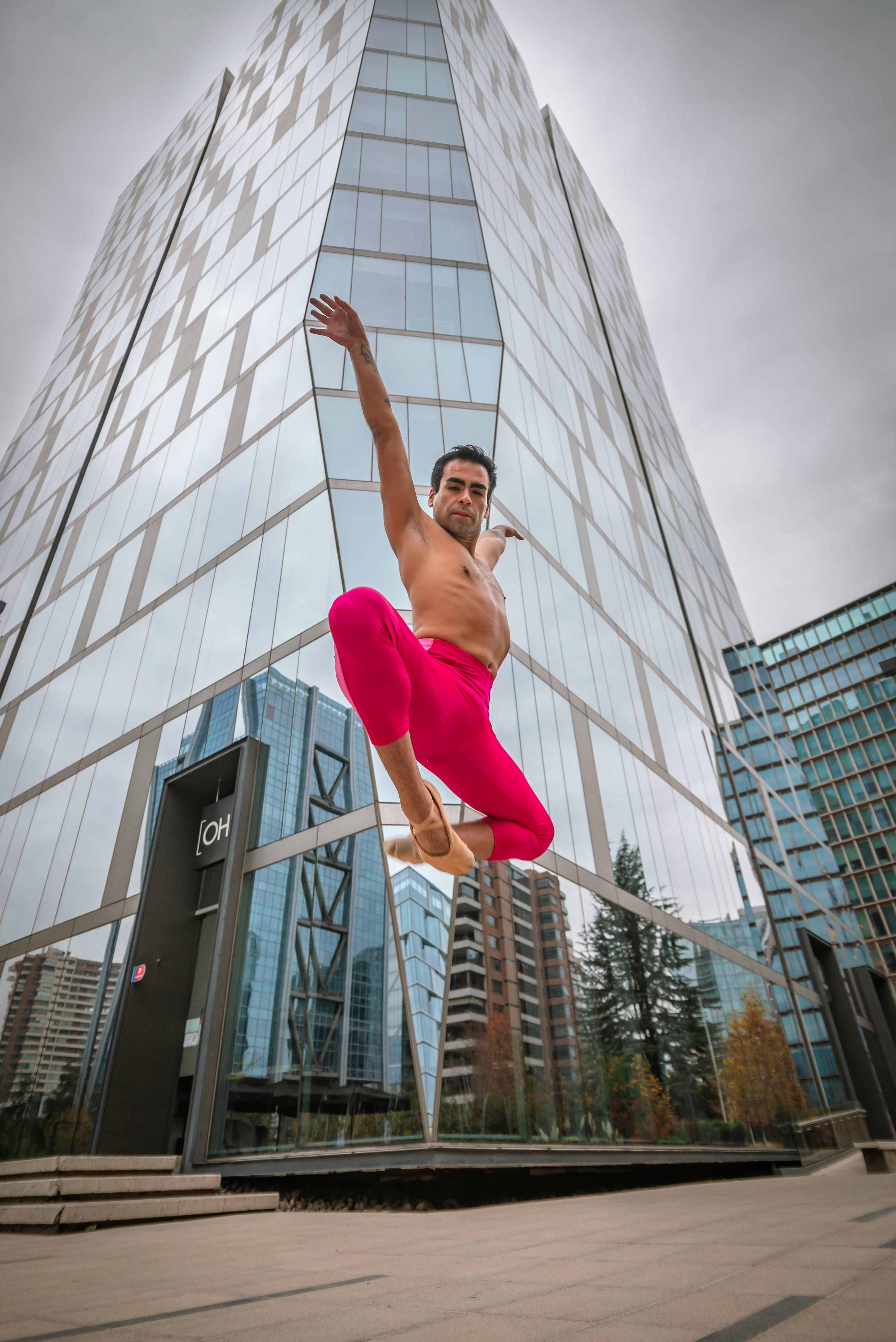 Male Dancer Leaping in Urban Setting with Skyscraper · Free Stock Photo