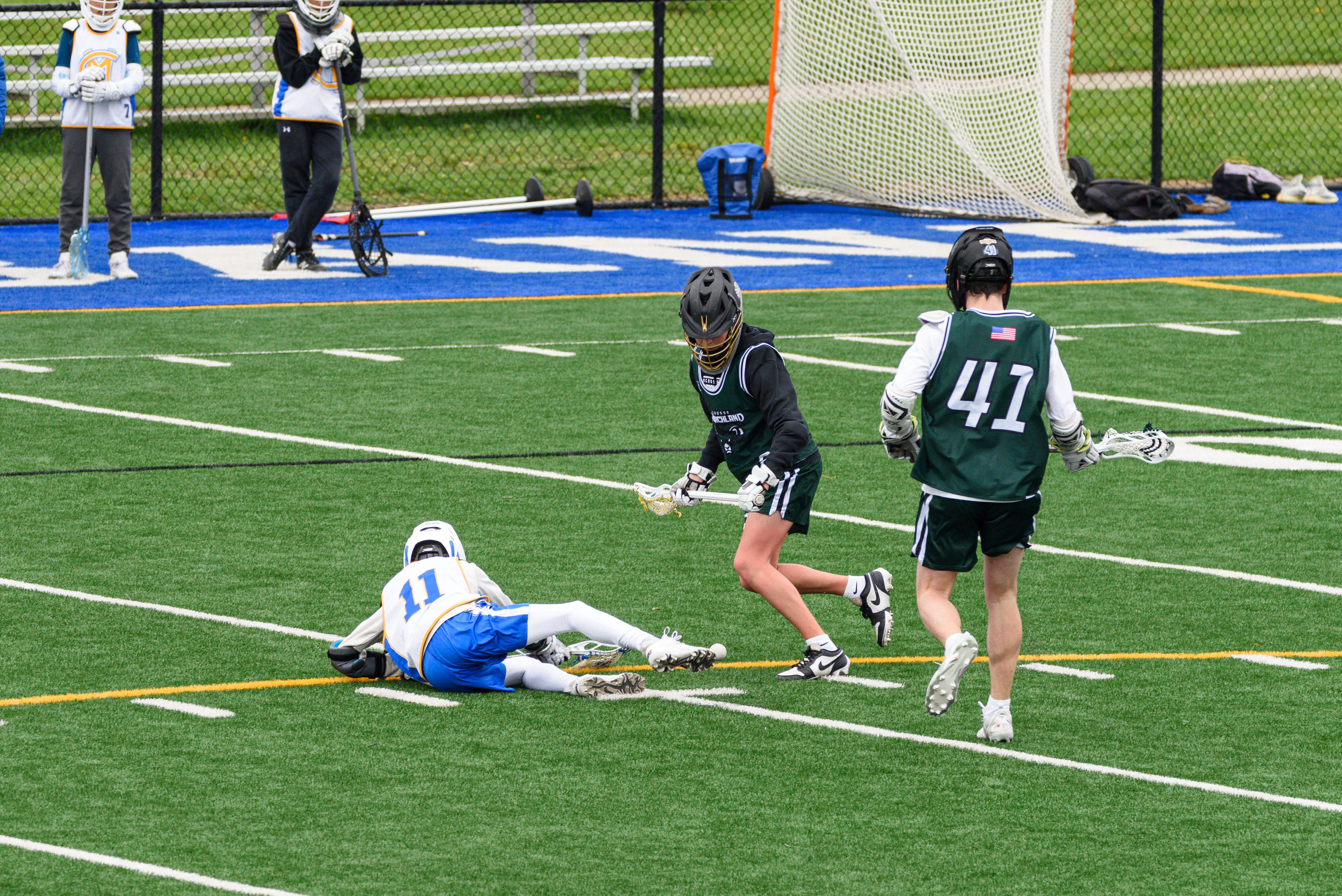 Action-Packed Lacrosse Game on Green Field · Free Stock Photo