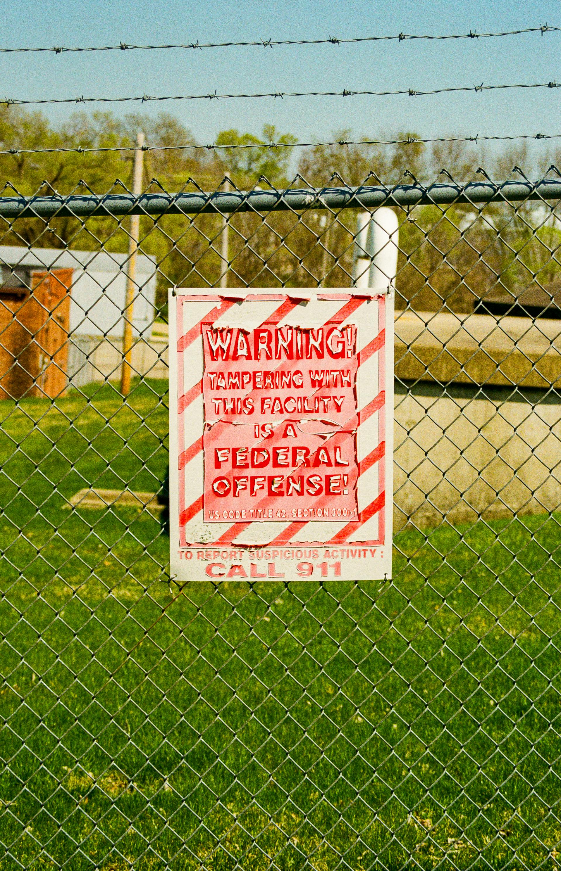 Warning Sign on Fence Protecting Federal Property · Free Stock Photo