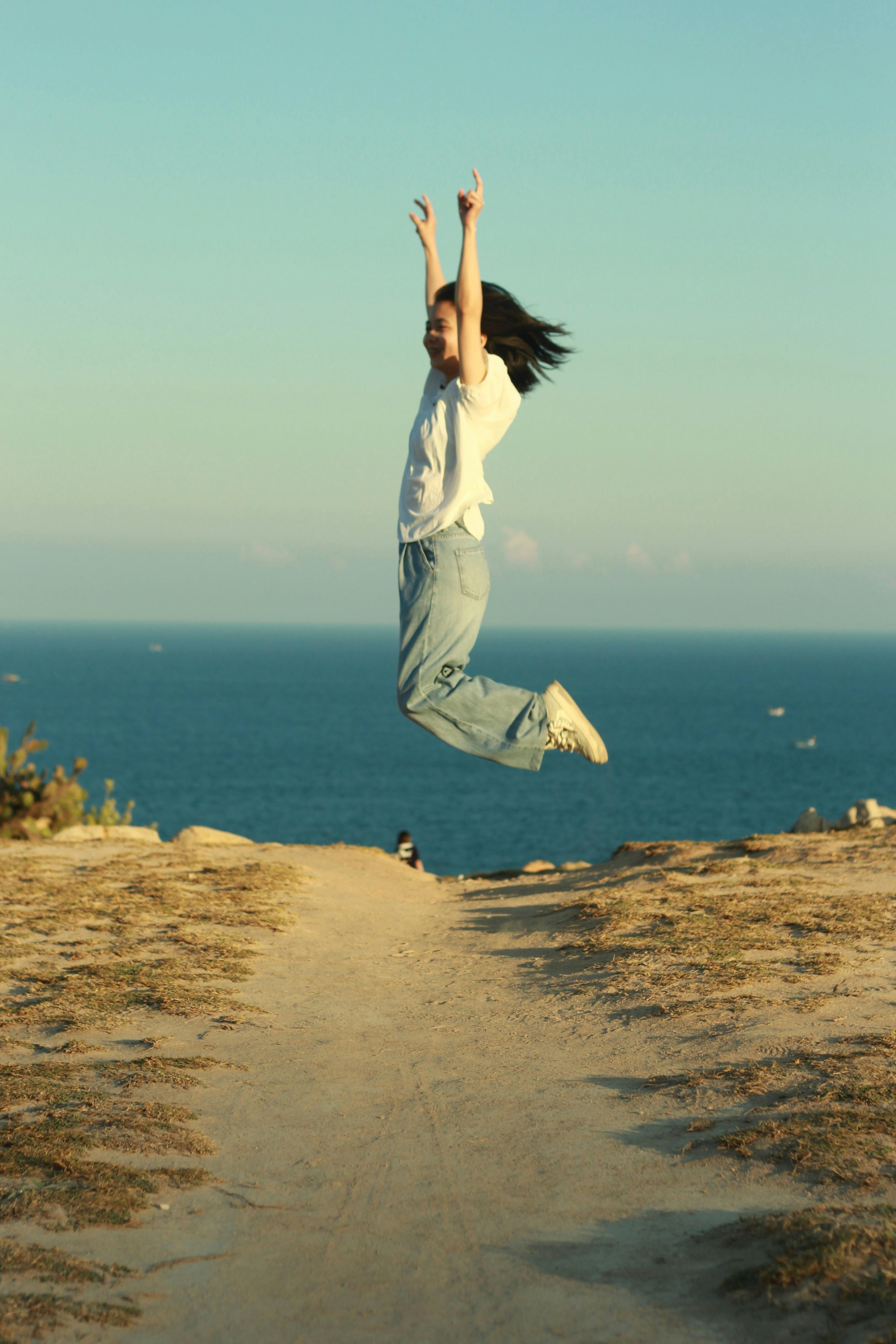 Joyful Youth Jumping by the Scenic Vietnam Coast · Free Stock Photo