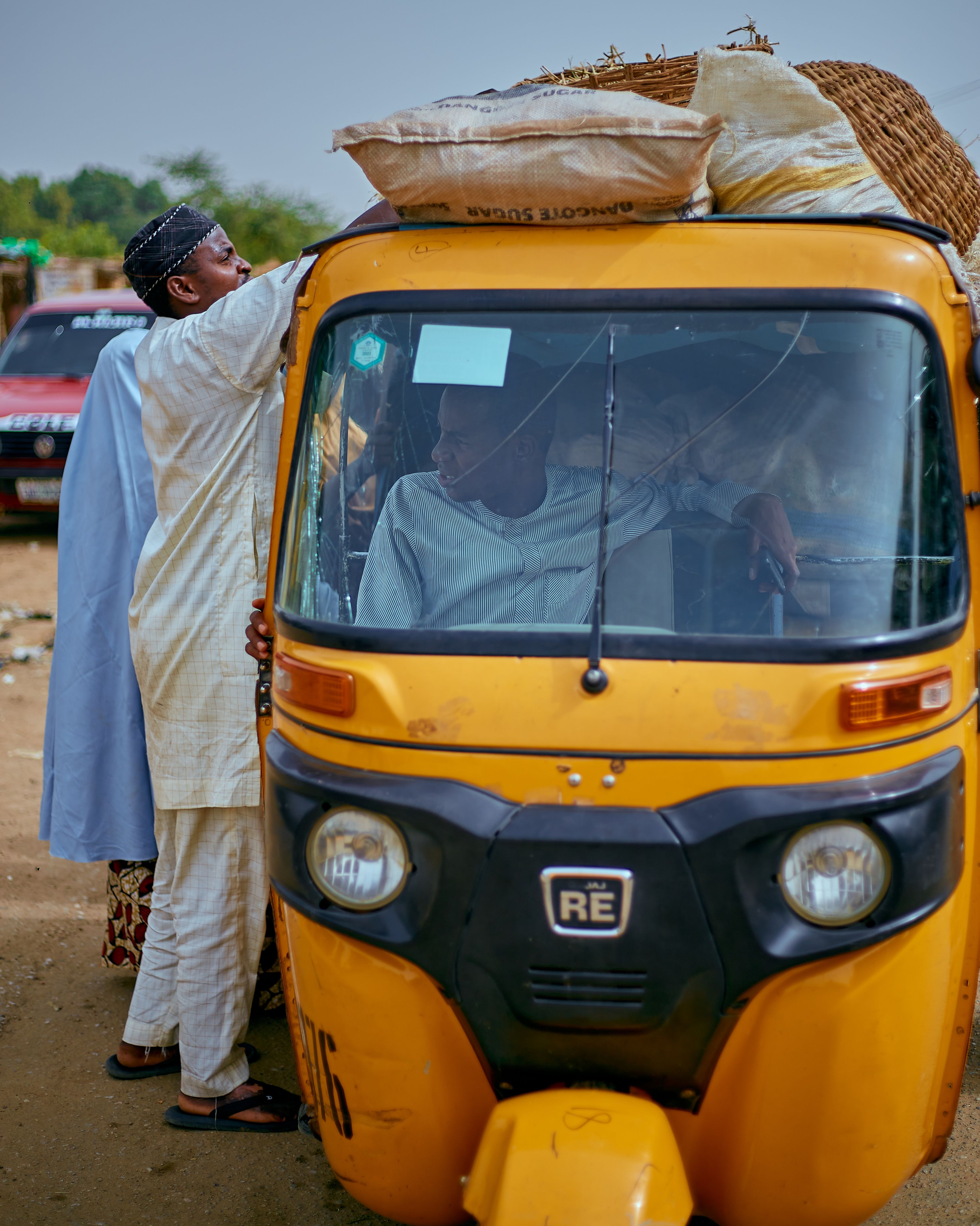 Yellow auto rickshaw with passengers and cargo · Free Stock Photo