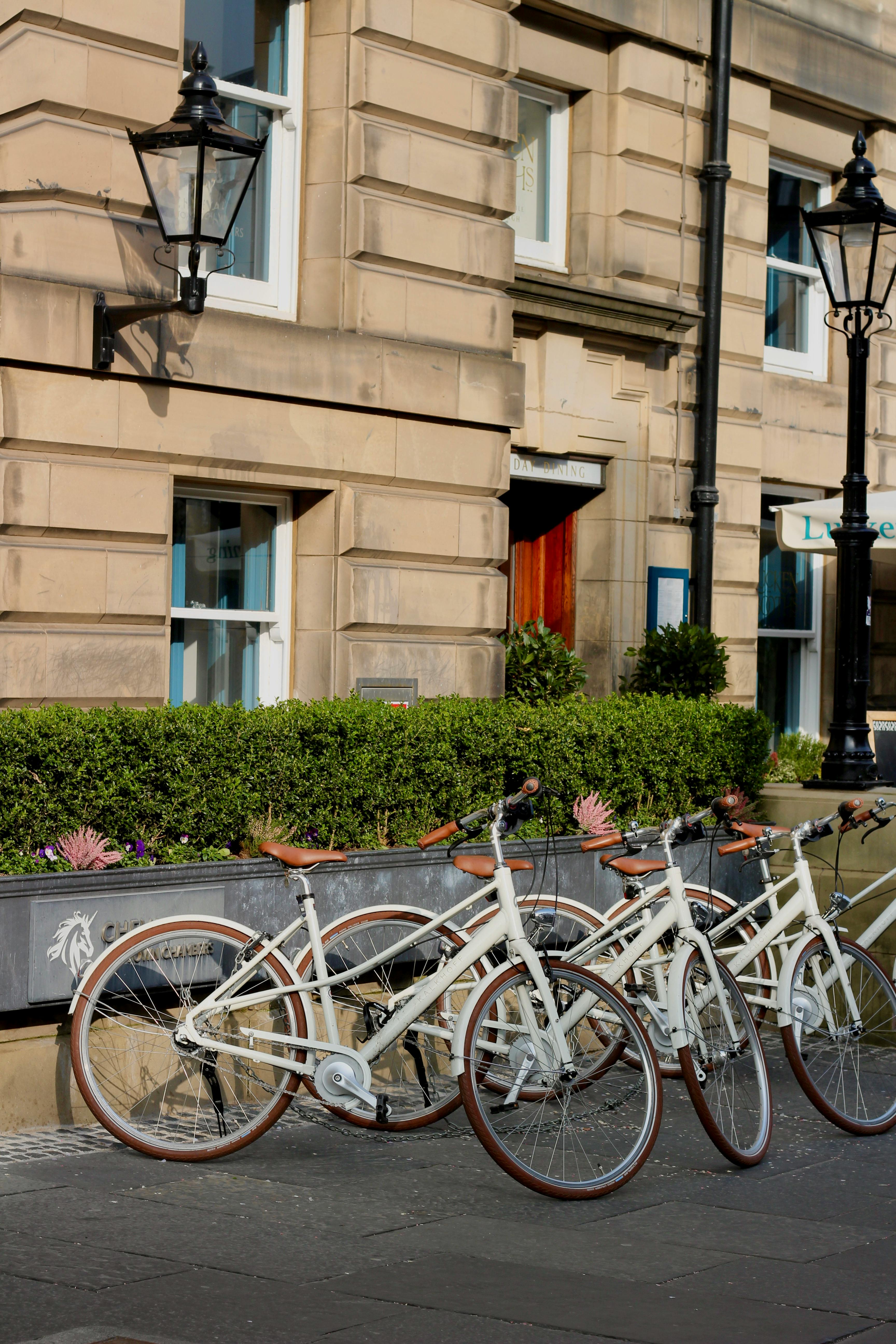Vintage Bicycles Parked Outside Stone Building · Free Stock Photo