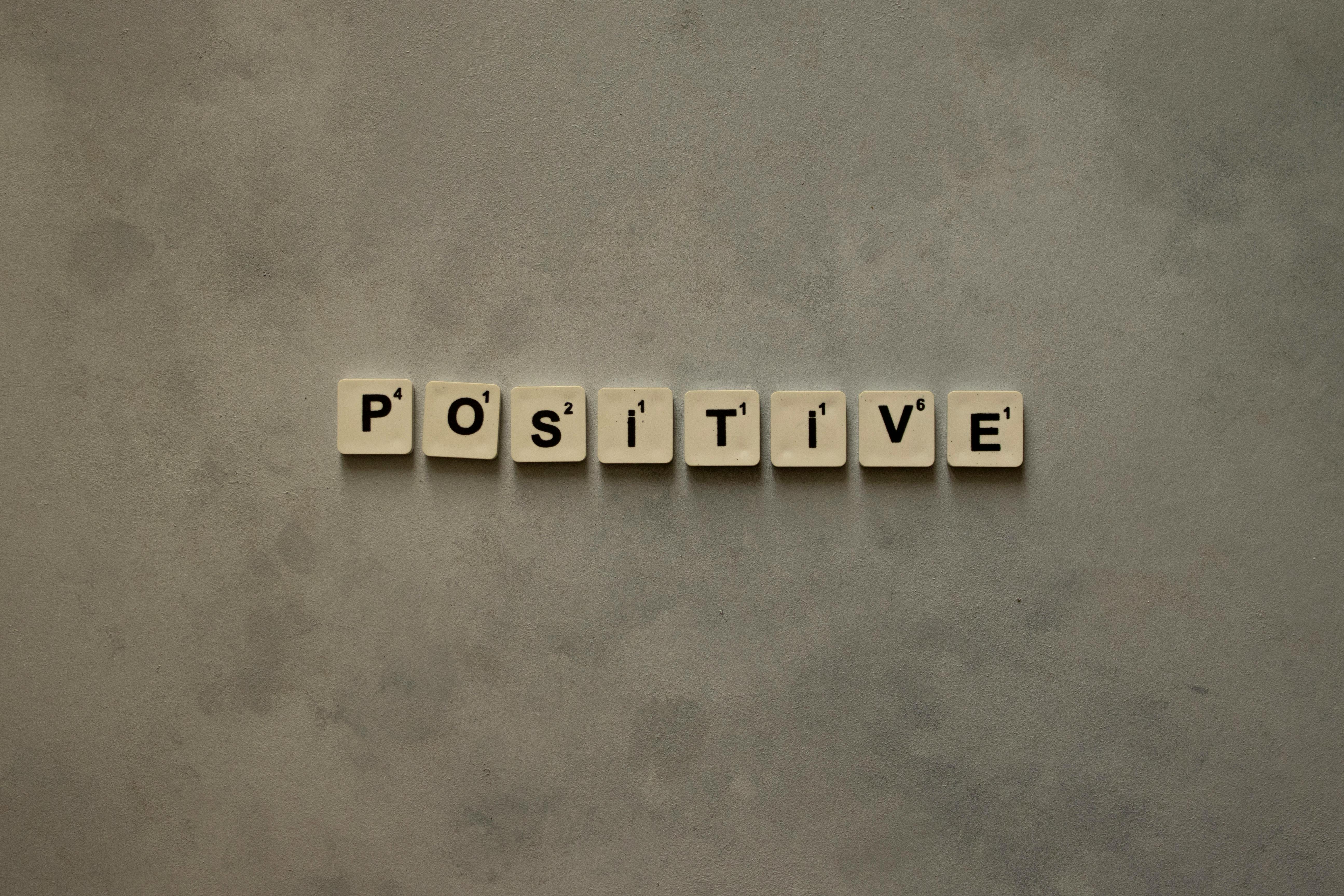 Positive Message in Scrabble Tiles on Texture · Free Stock Photo
