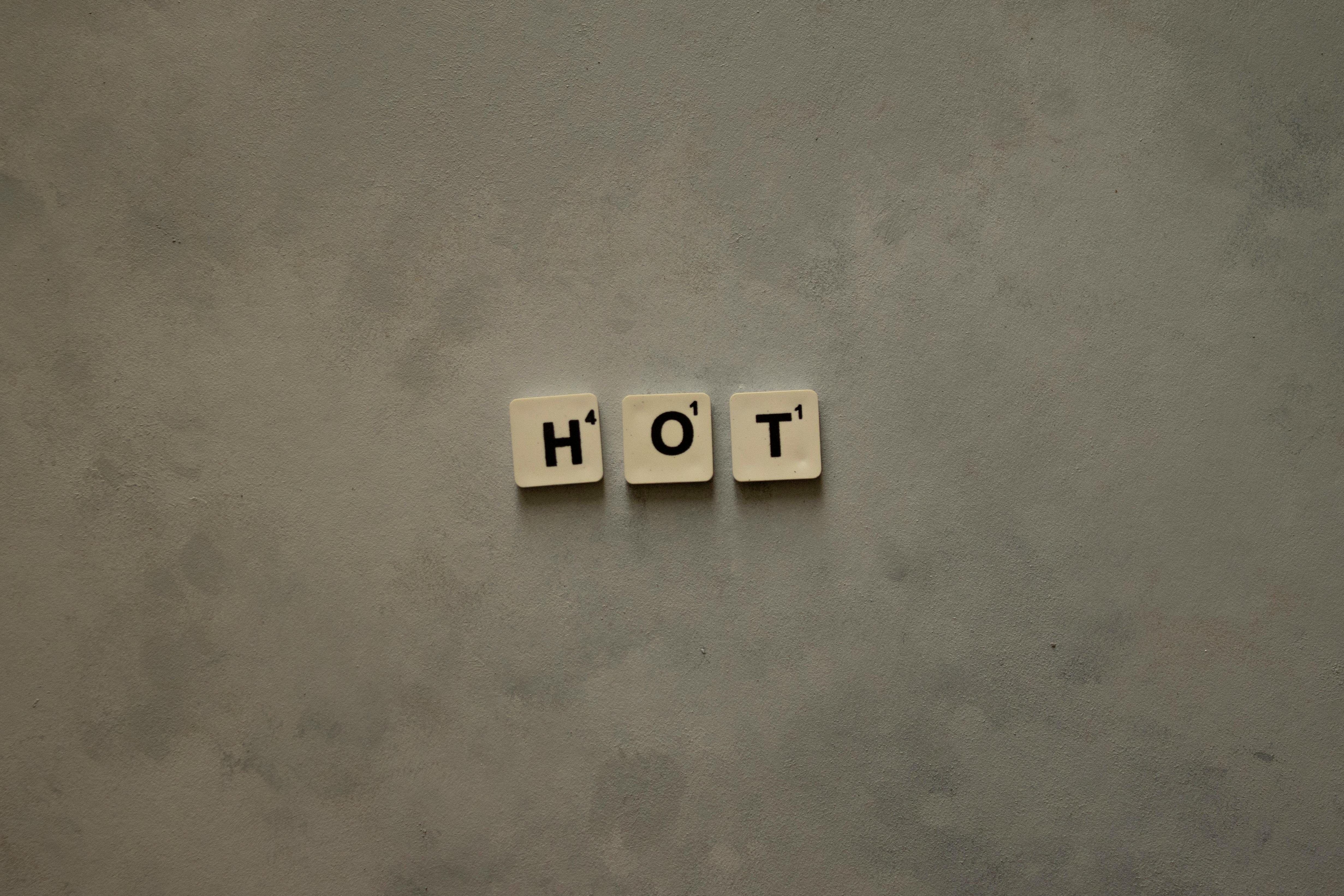 Scrabble Tiles Spelling 'HOT' on Gray Background · Free Stock Photo