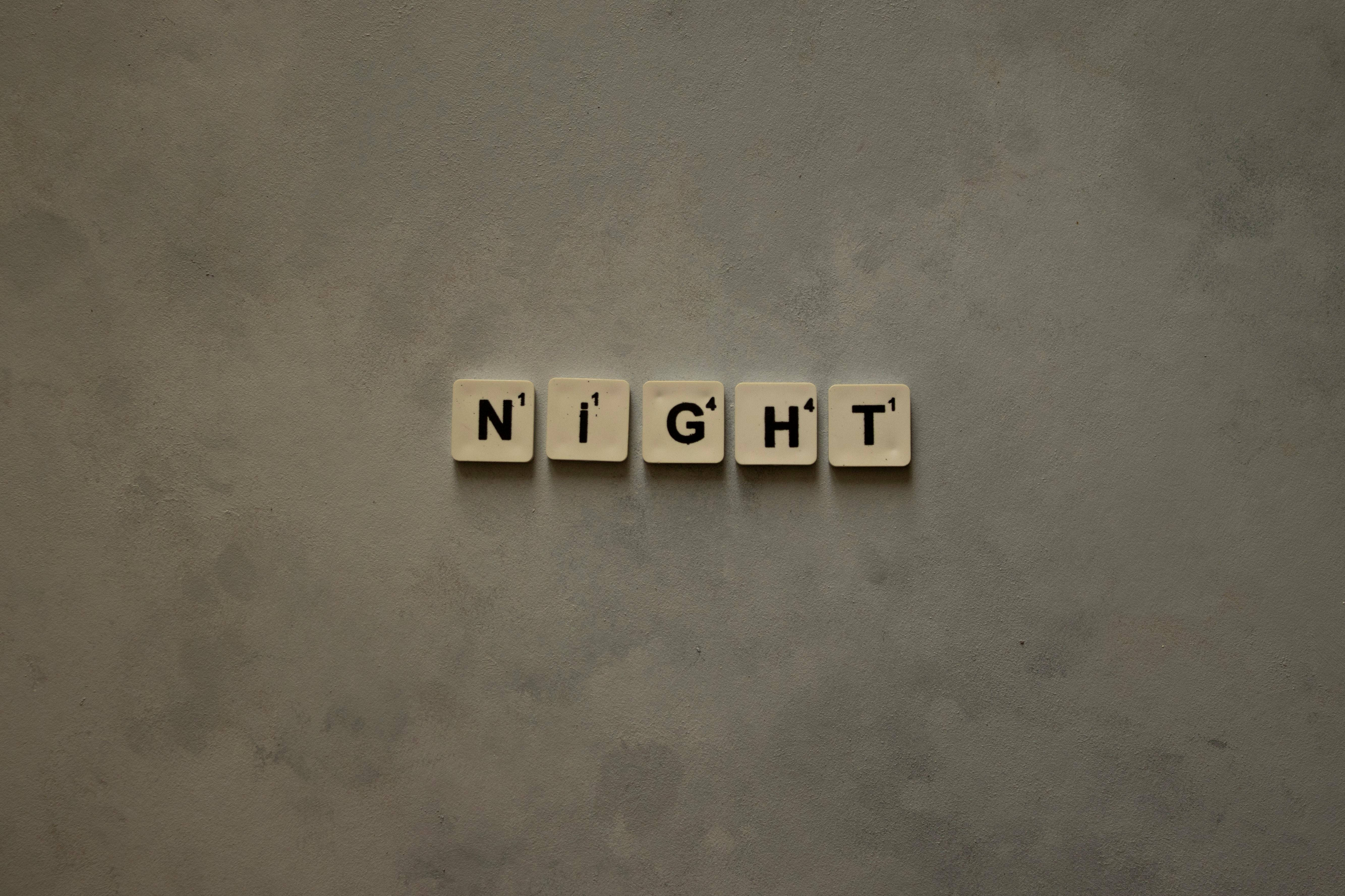 Scrabble Letters Spelling Night on Gray Background · Free Stock Photo