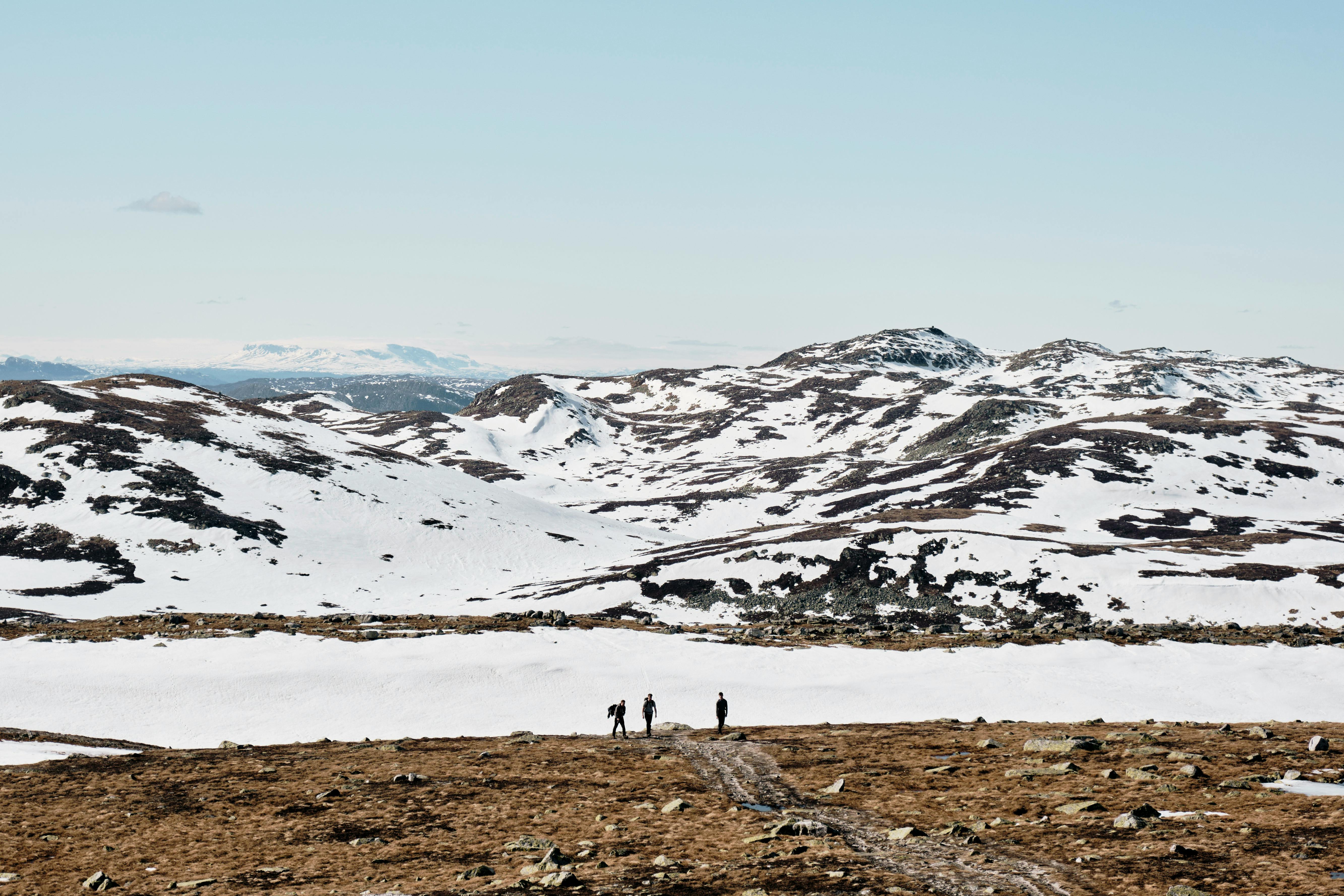 Hikers Traversing Snowy Mountain Terrain · Free Stock Photo