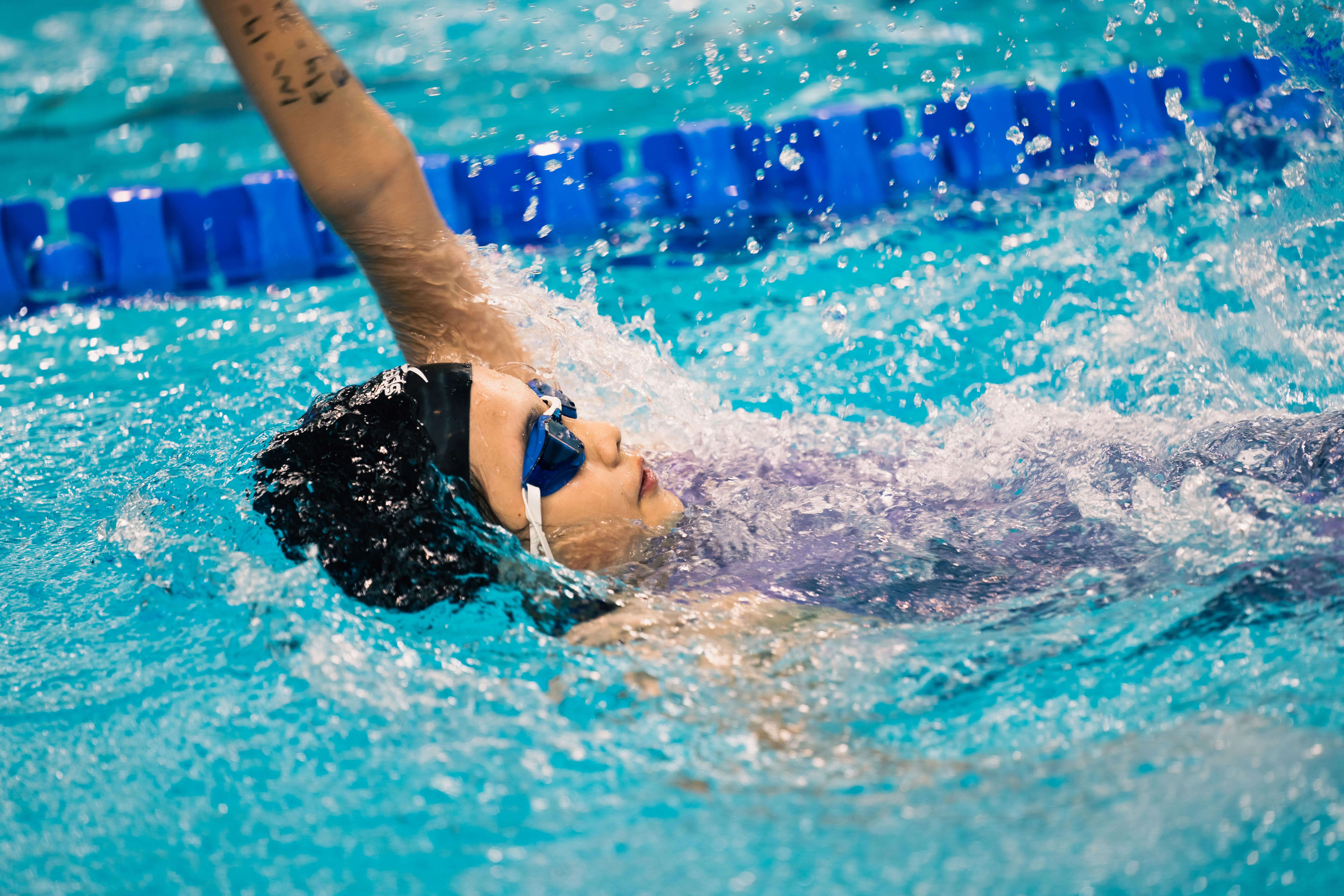 Competitive Swimmer Performing Backstroke in Pool · Free Stock Photo