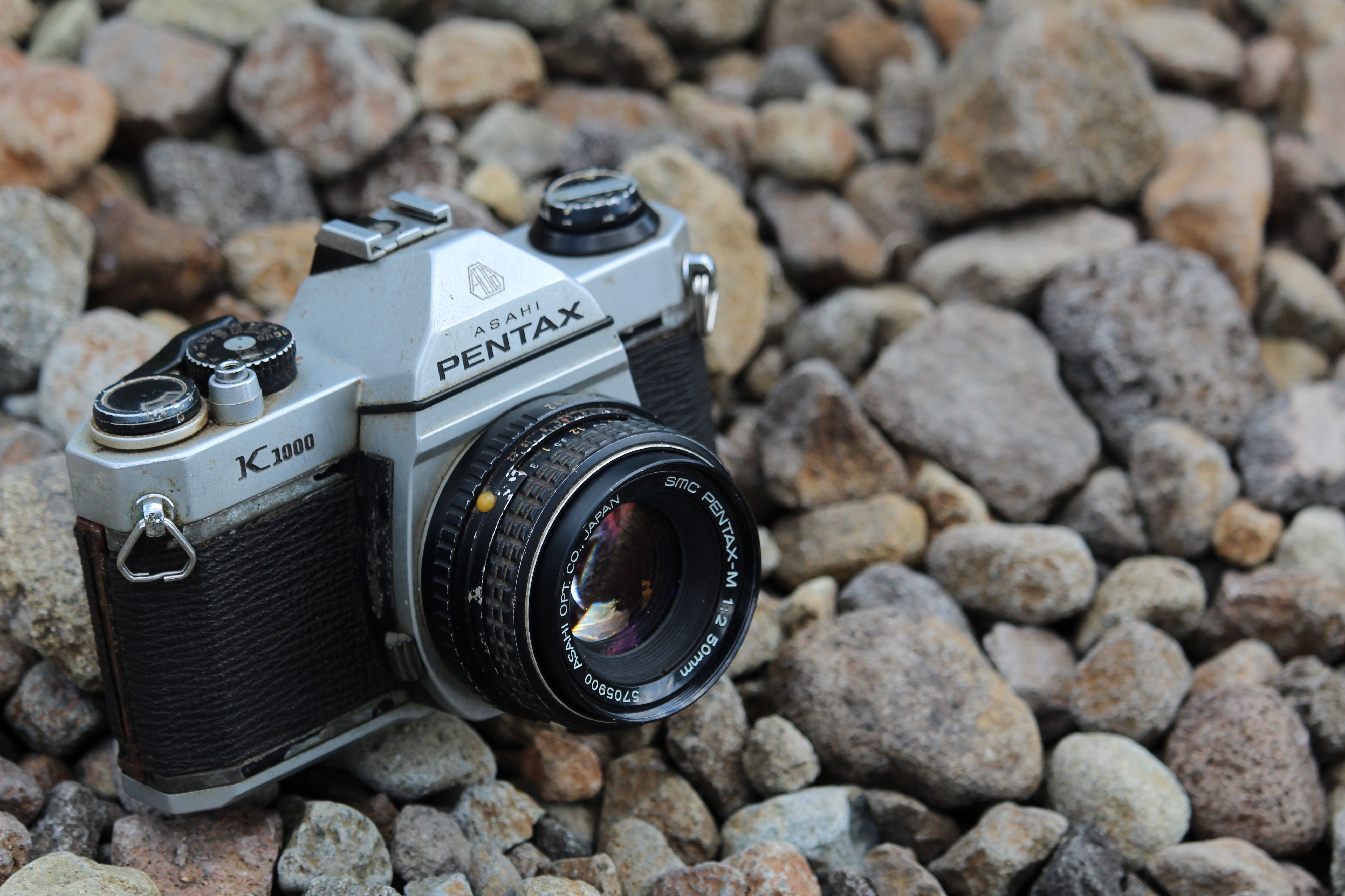 Vintage Pentax K1000 Camera on Pebbles · Free Stock Photo