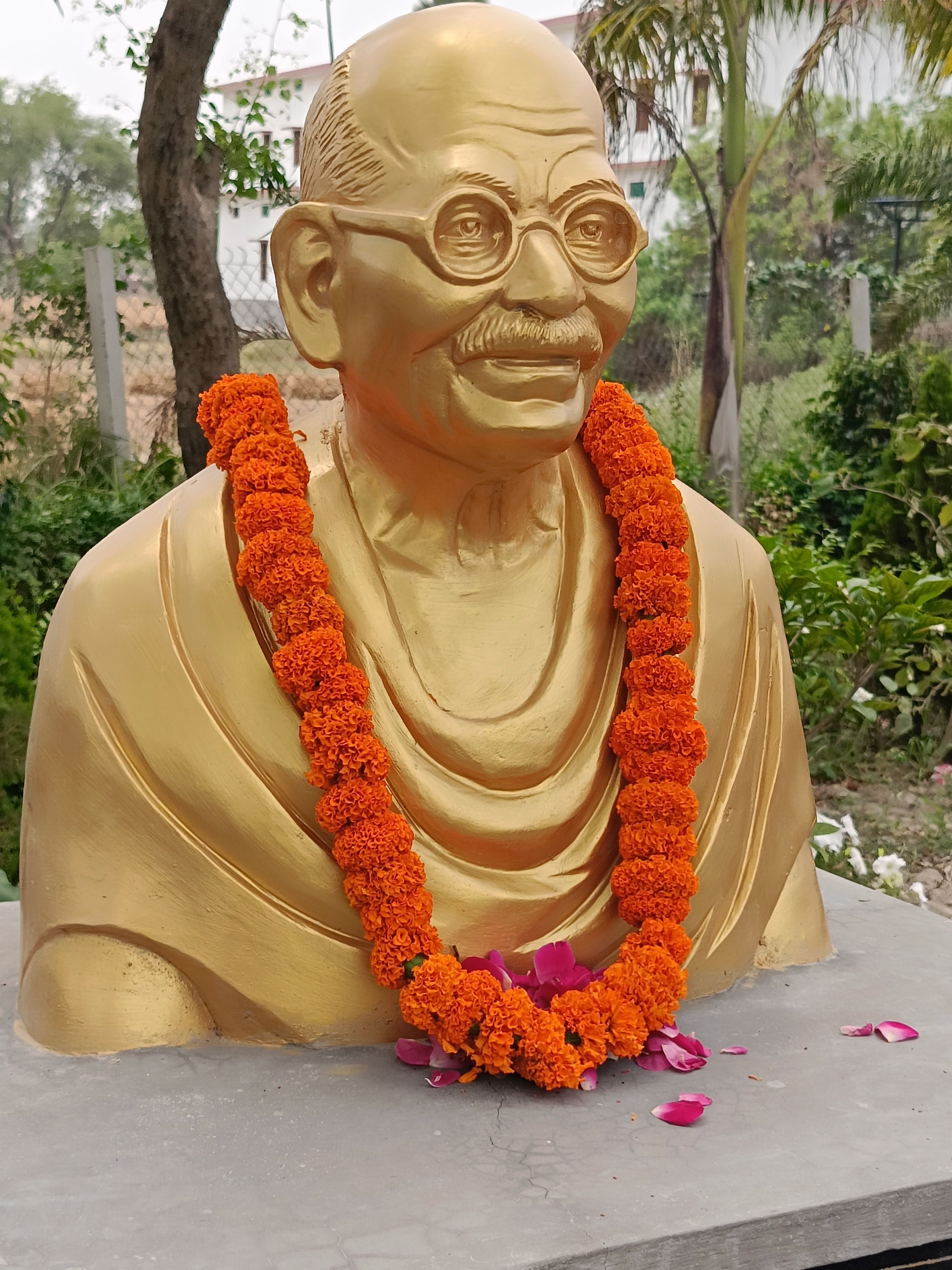 Gold Statue of Iconic Figure with Flower Garland · Free Stock Photo