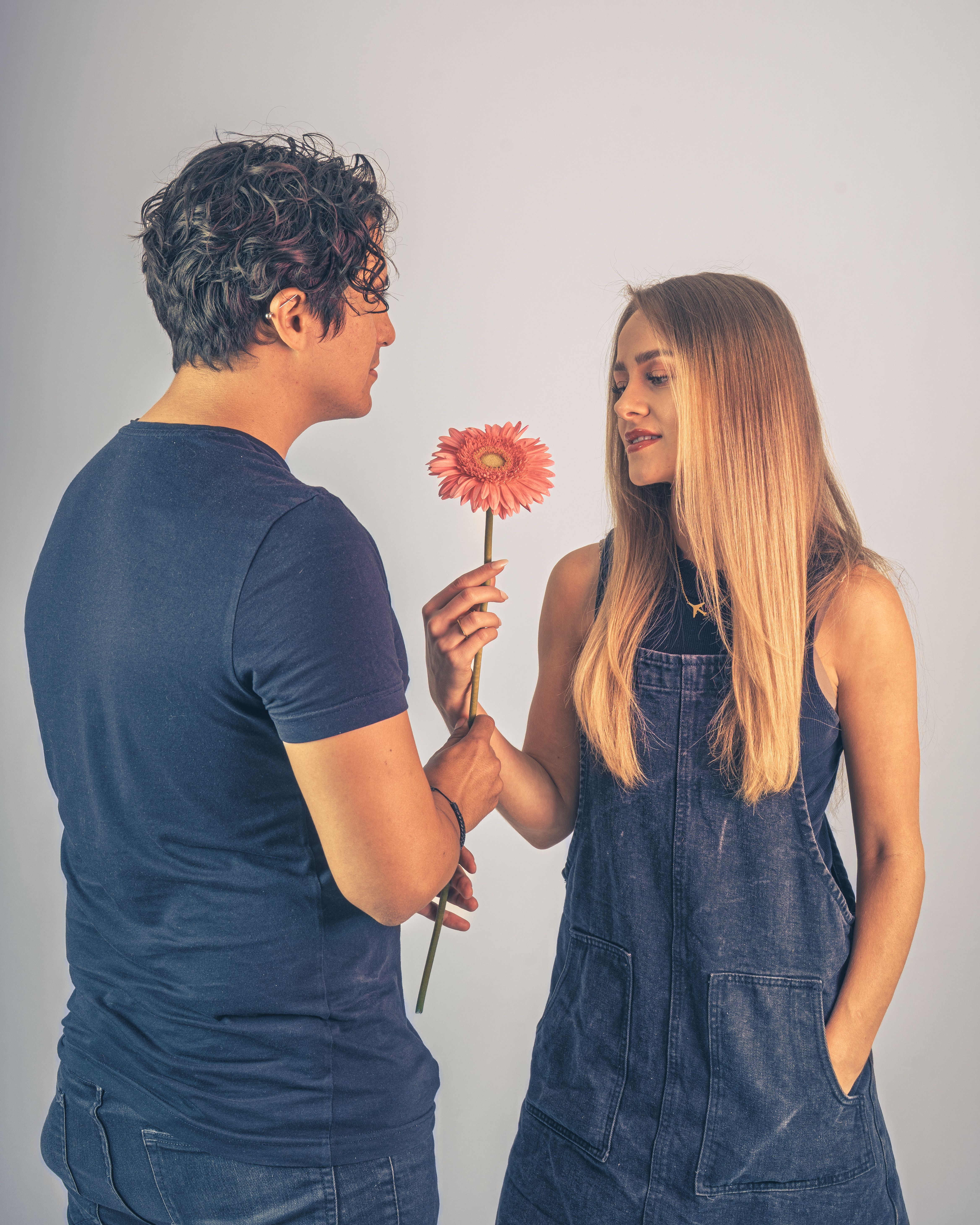 Young Couple Sharing a Flower Indoors · Free Stock Photo