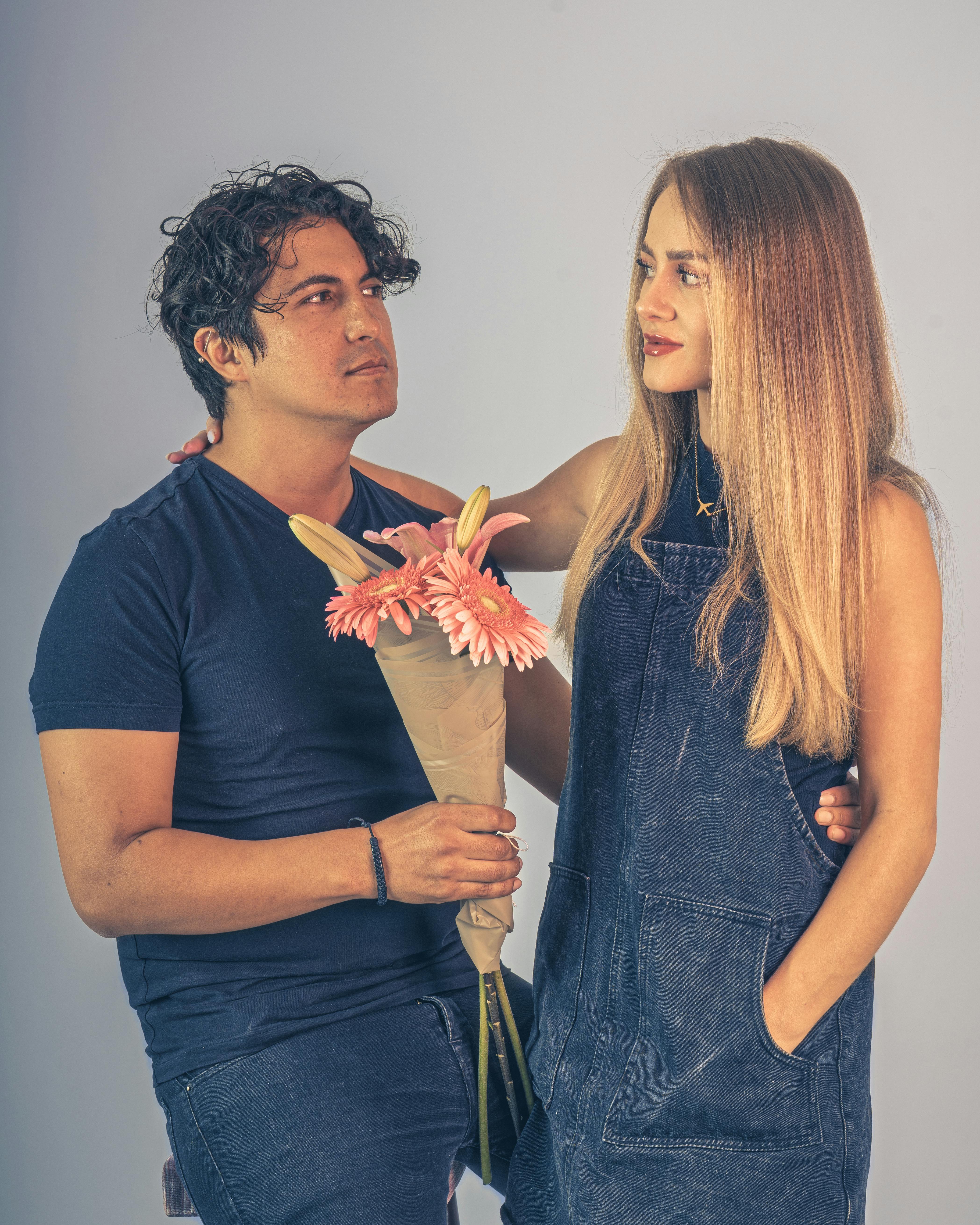 Young Couple with Flowers in Studio Setting · Free Stock Photo