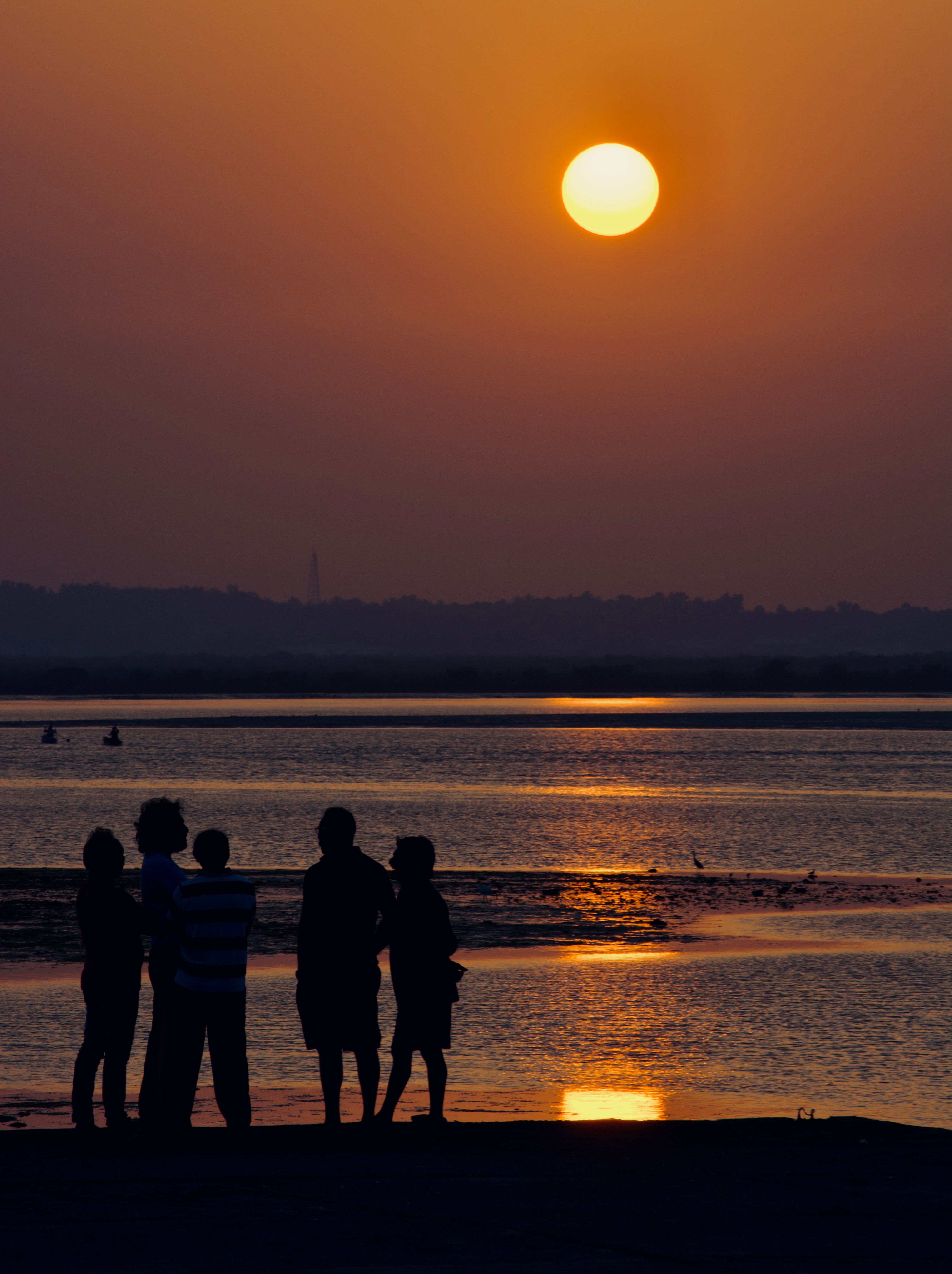 Silhouetted Group Enjoys Scenic Sunset by the Lake · Free Stock Photo