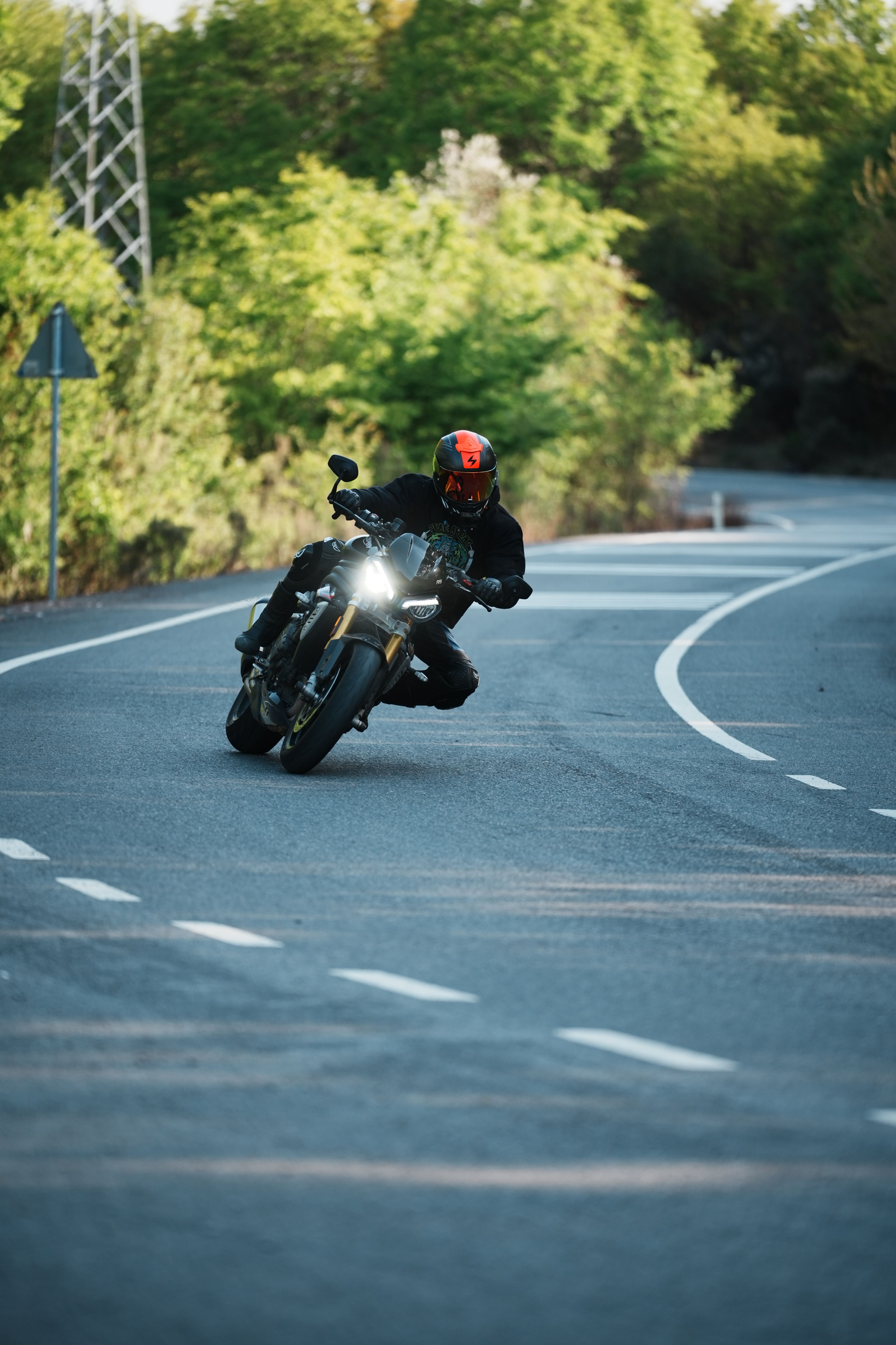 Motorcyclist Leaning into Curve on Sunny Day · Free Stock Photo