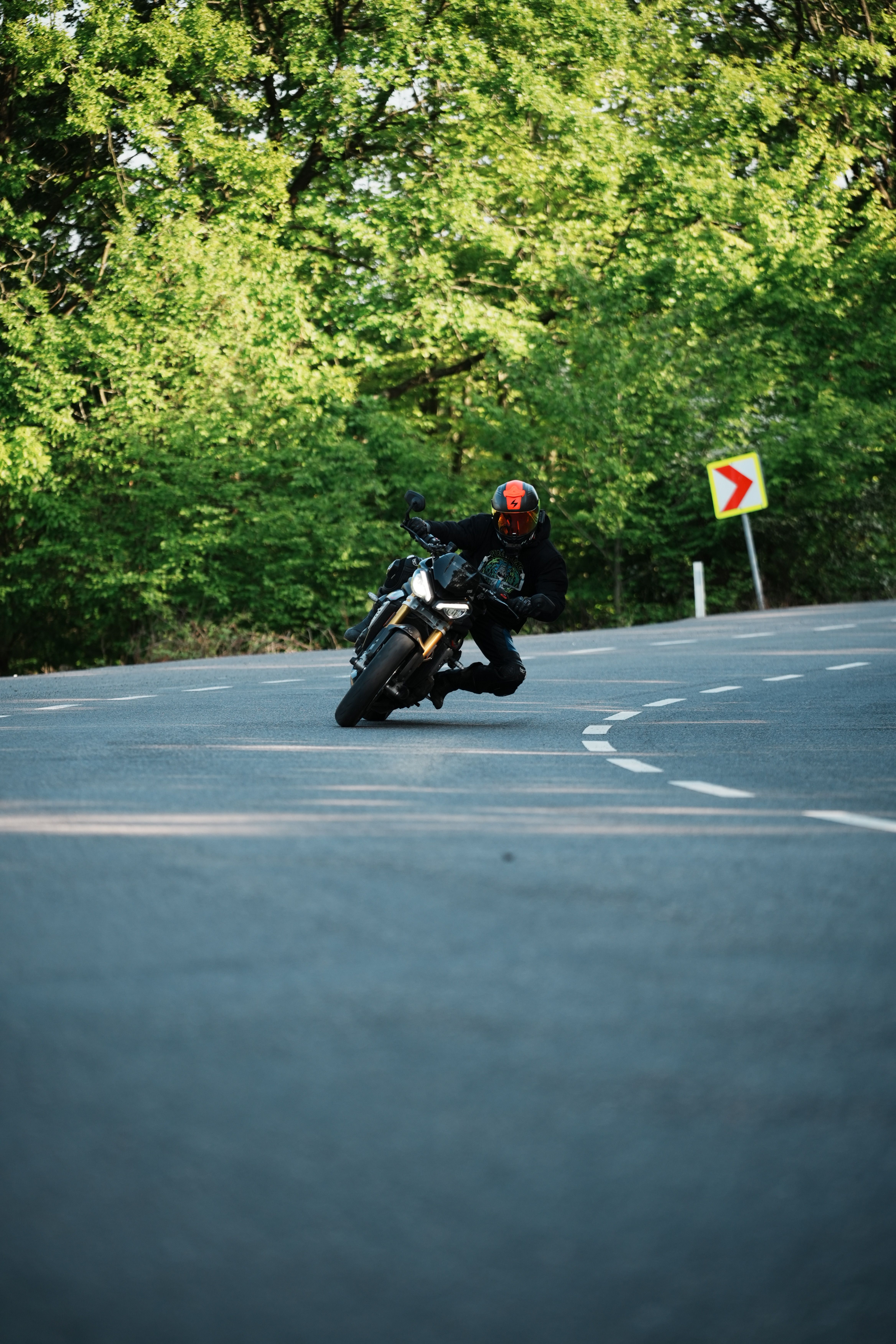 Motorcyclist Leaning into Sharp Curve on Scenic Road · Free Stock Photo
