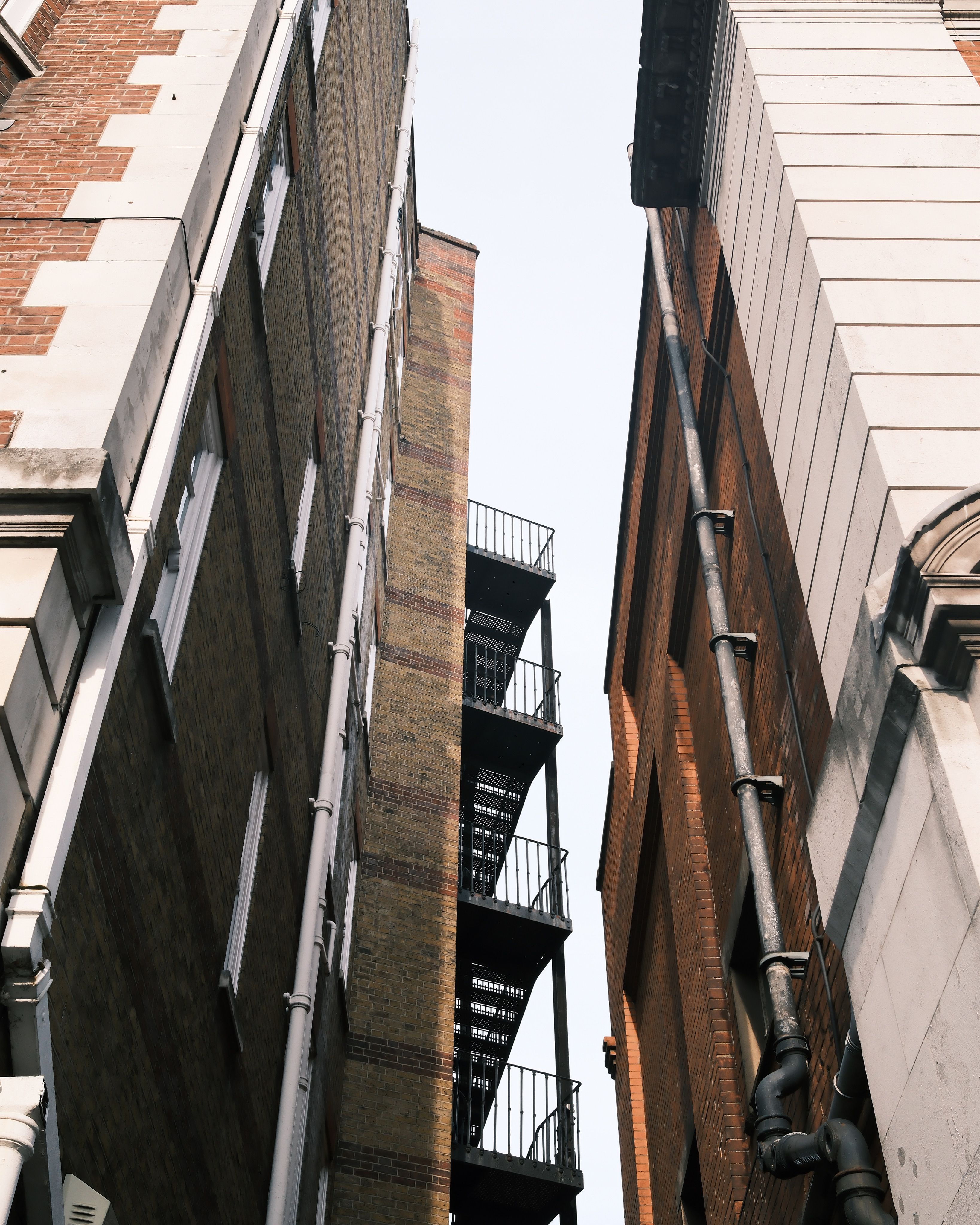 Urban Alleyway with Fire Escape and Brick Buildings · Free Stock Photo