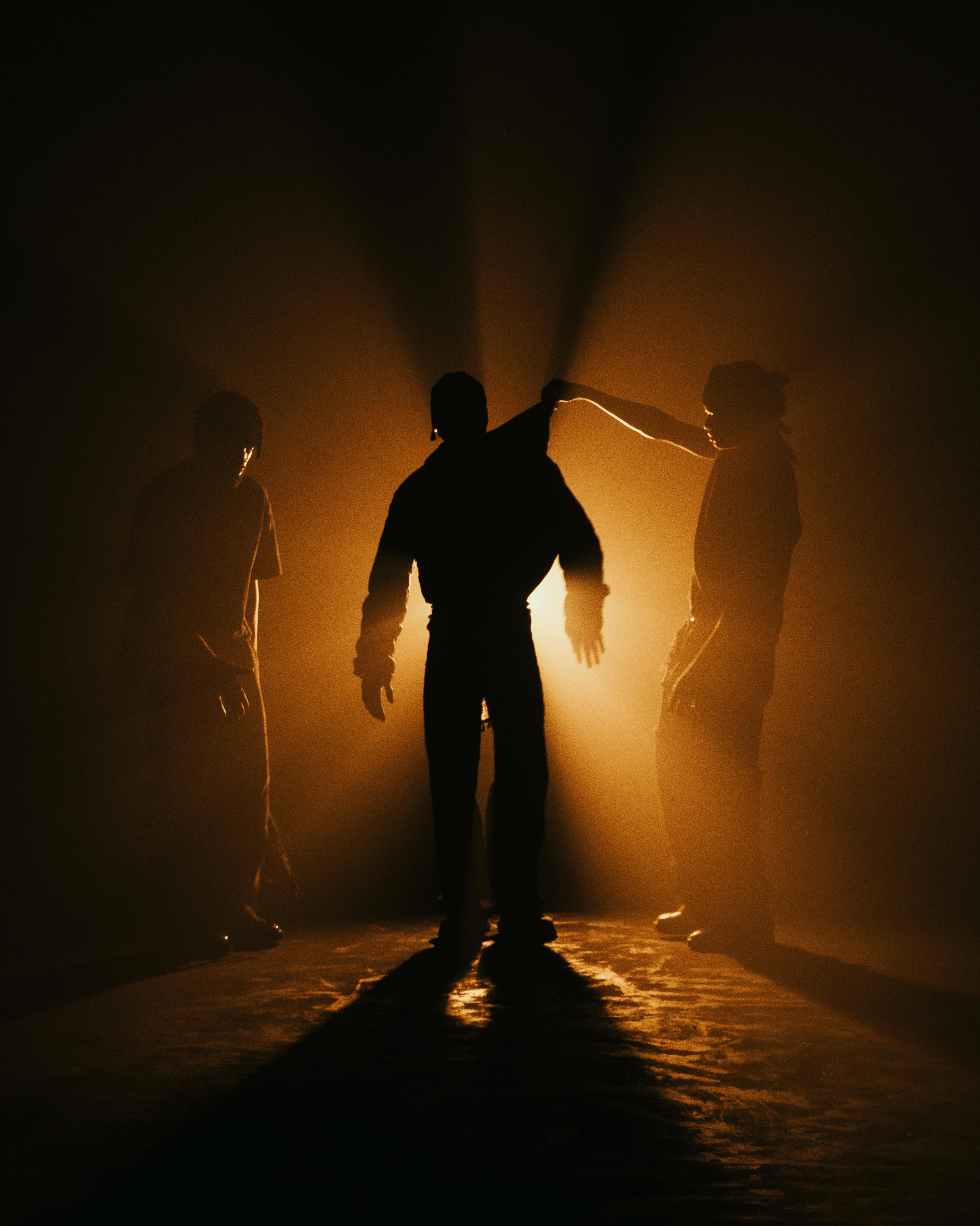 Silhouetted Figures in Dramatic Light Setting · Free Stock Photo