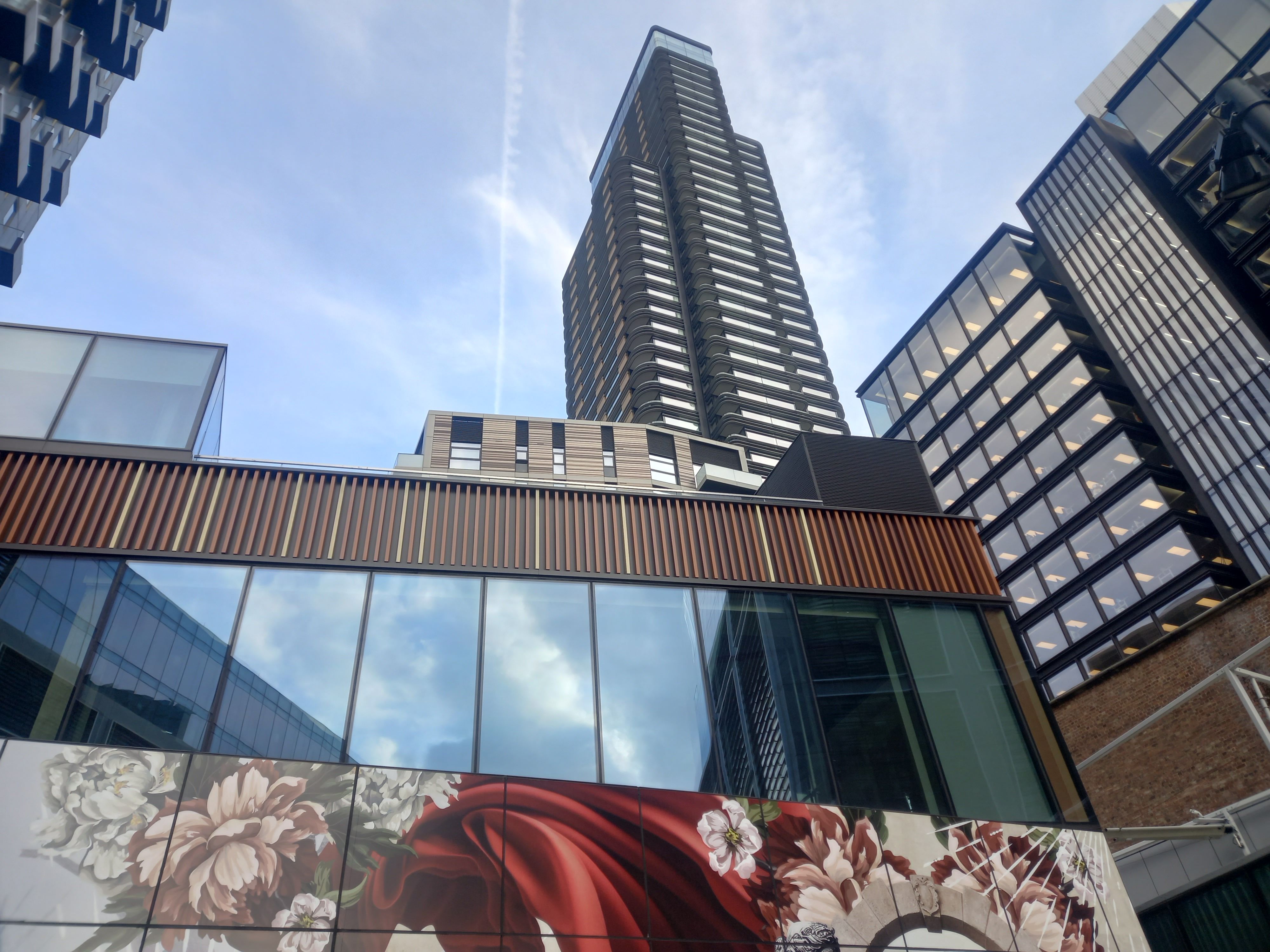 Modern Skyscraper with Floral Wall Art in Urban Setting · Free Stock Photo