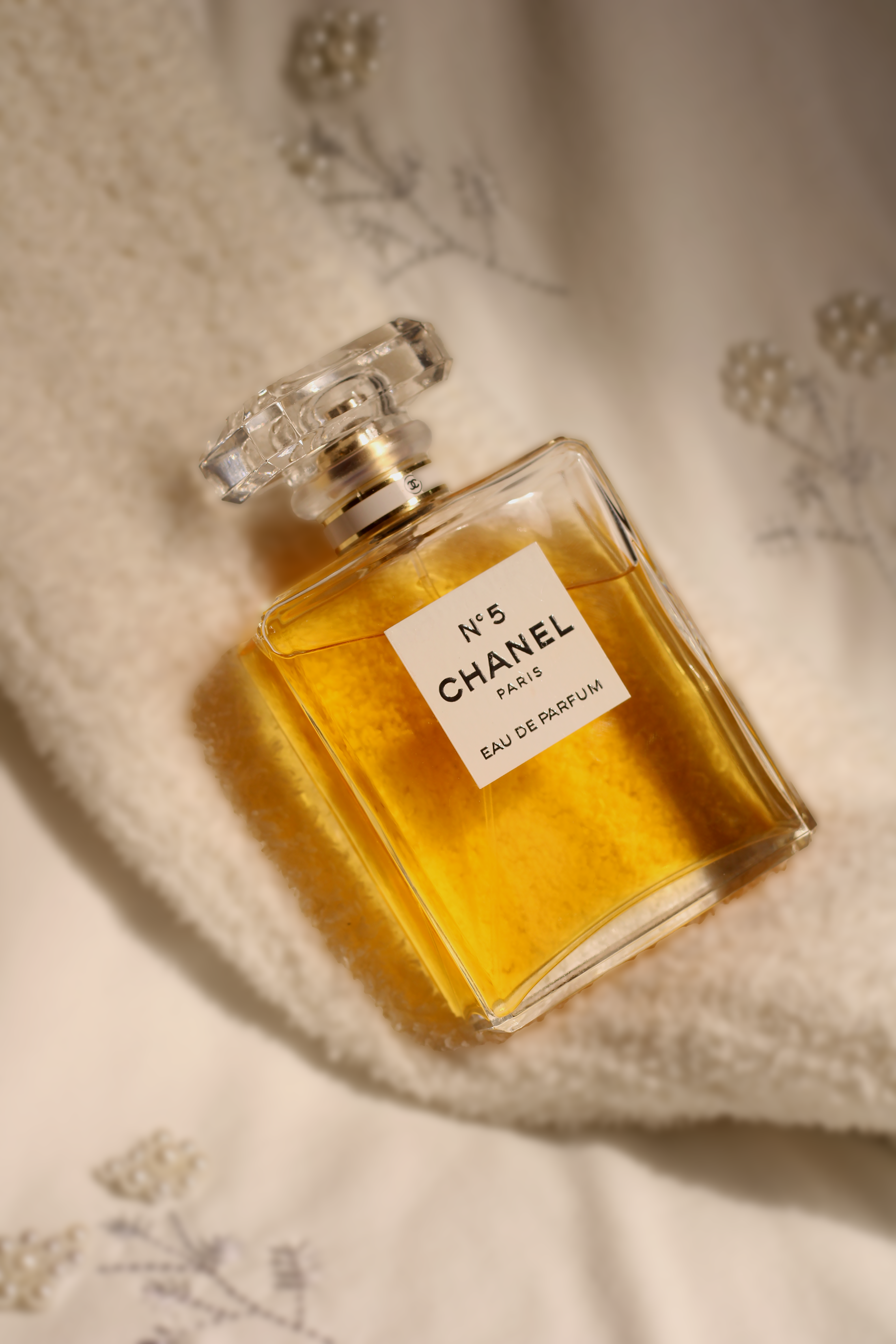 Luxury Chanel No. 5 Perfume Bottle on Soft Fabric · Free Stock Photo