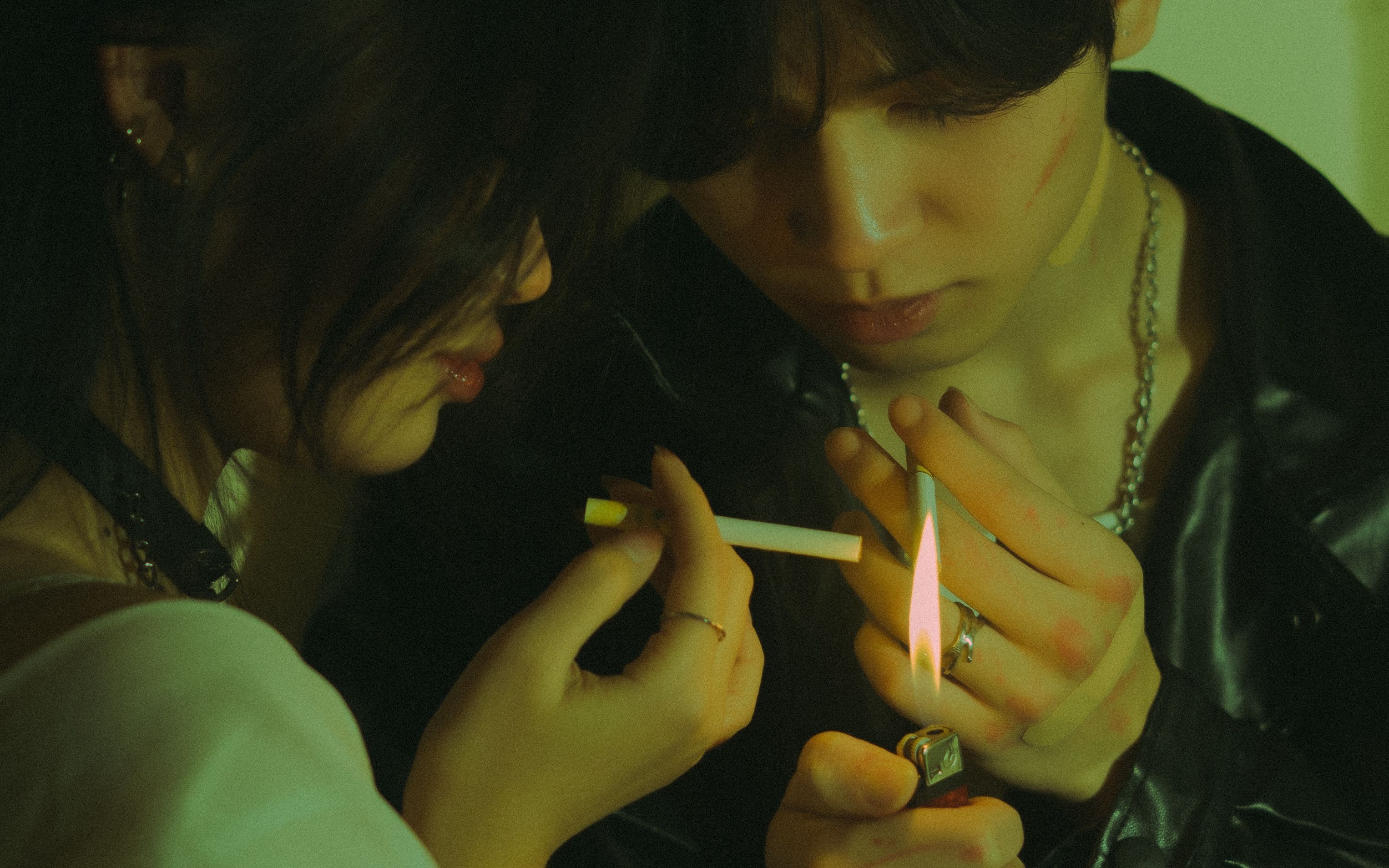 Young Couple Lighting Cigarettes in Moody Light · Free Stock Photo