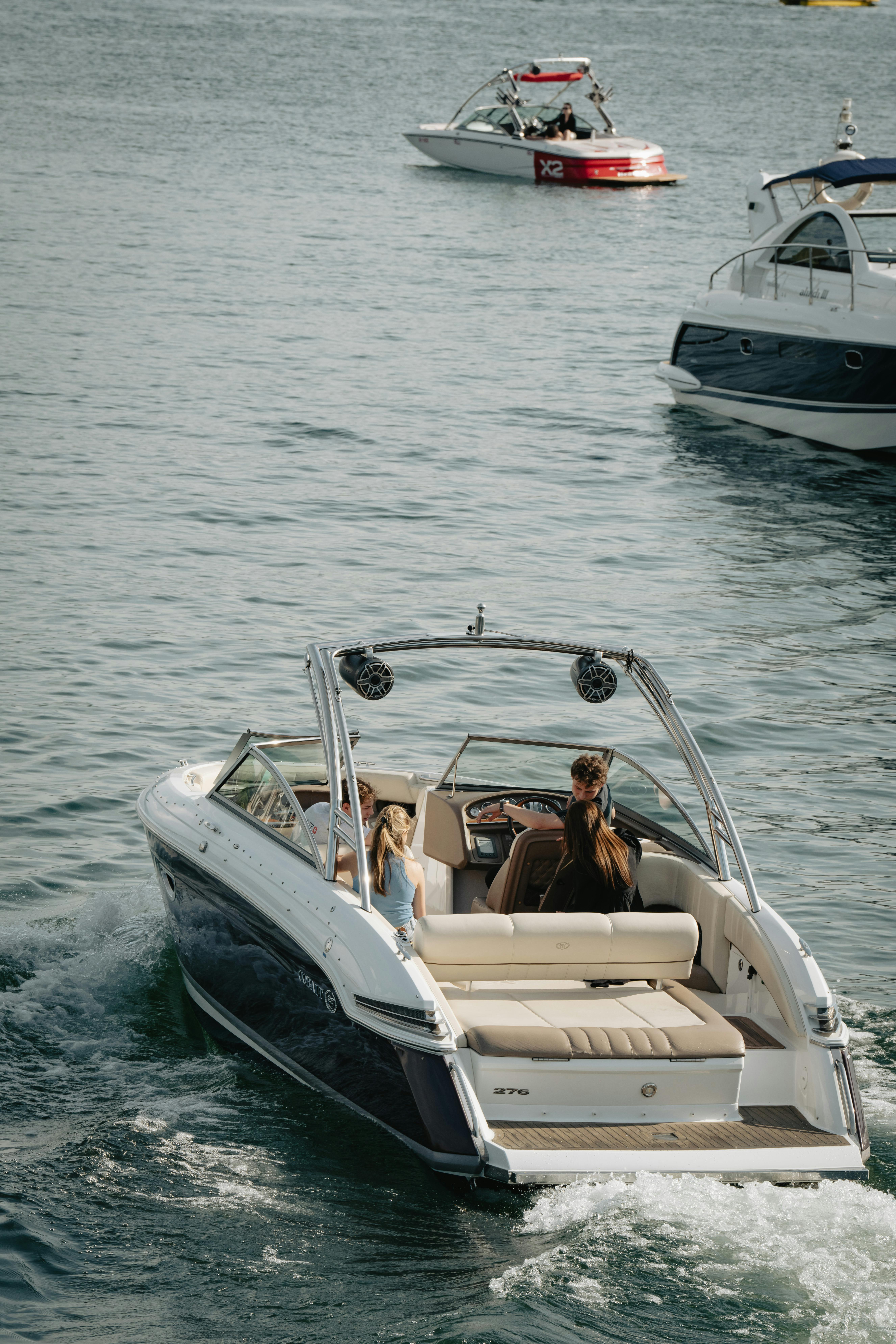 Woman Wearing Black Cap Holding Bottle on White Speedboat during ...