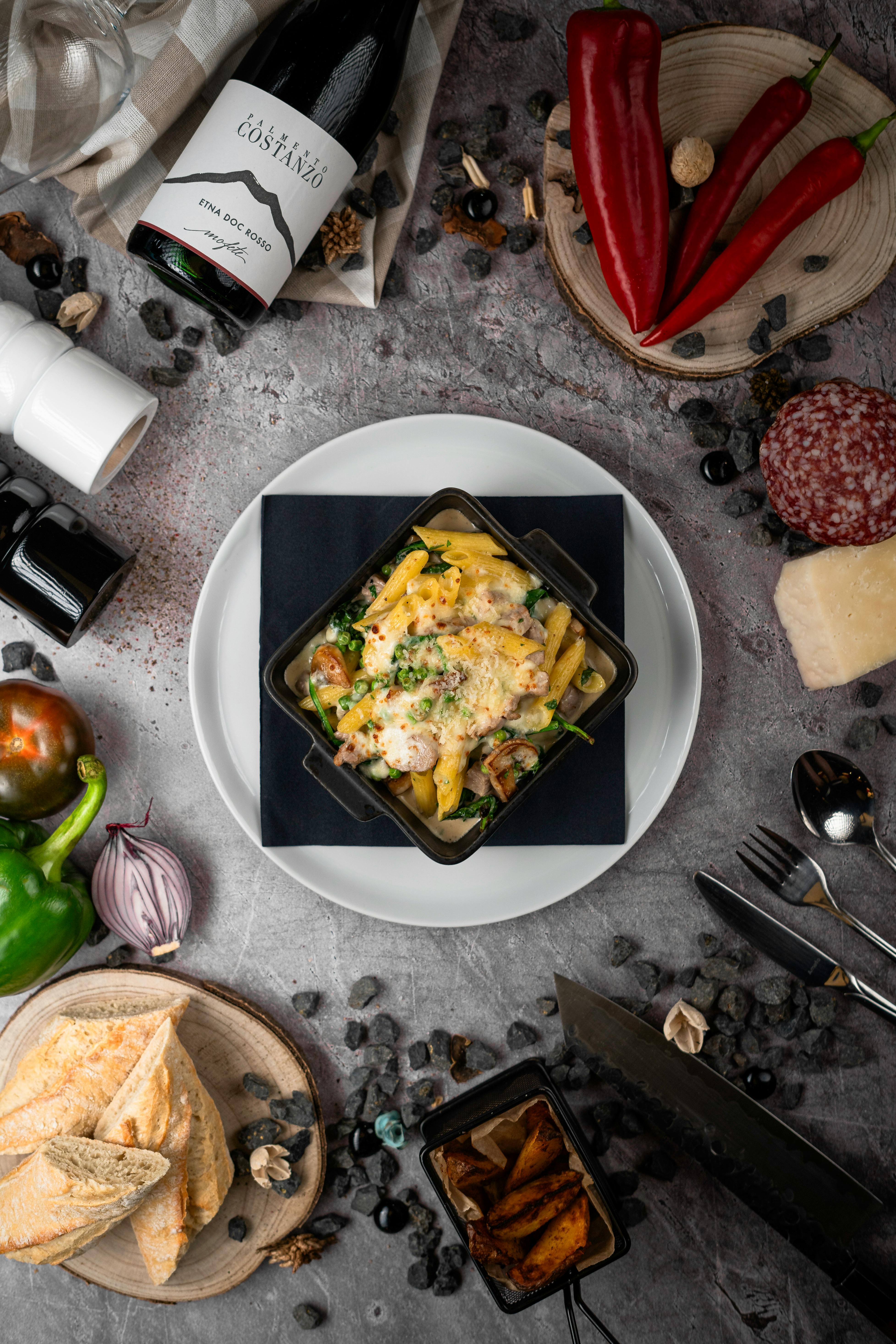 Gourmet Pasta Dinner with Wine and Peppers · Free Stock Photo