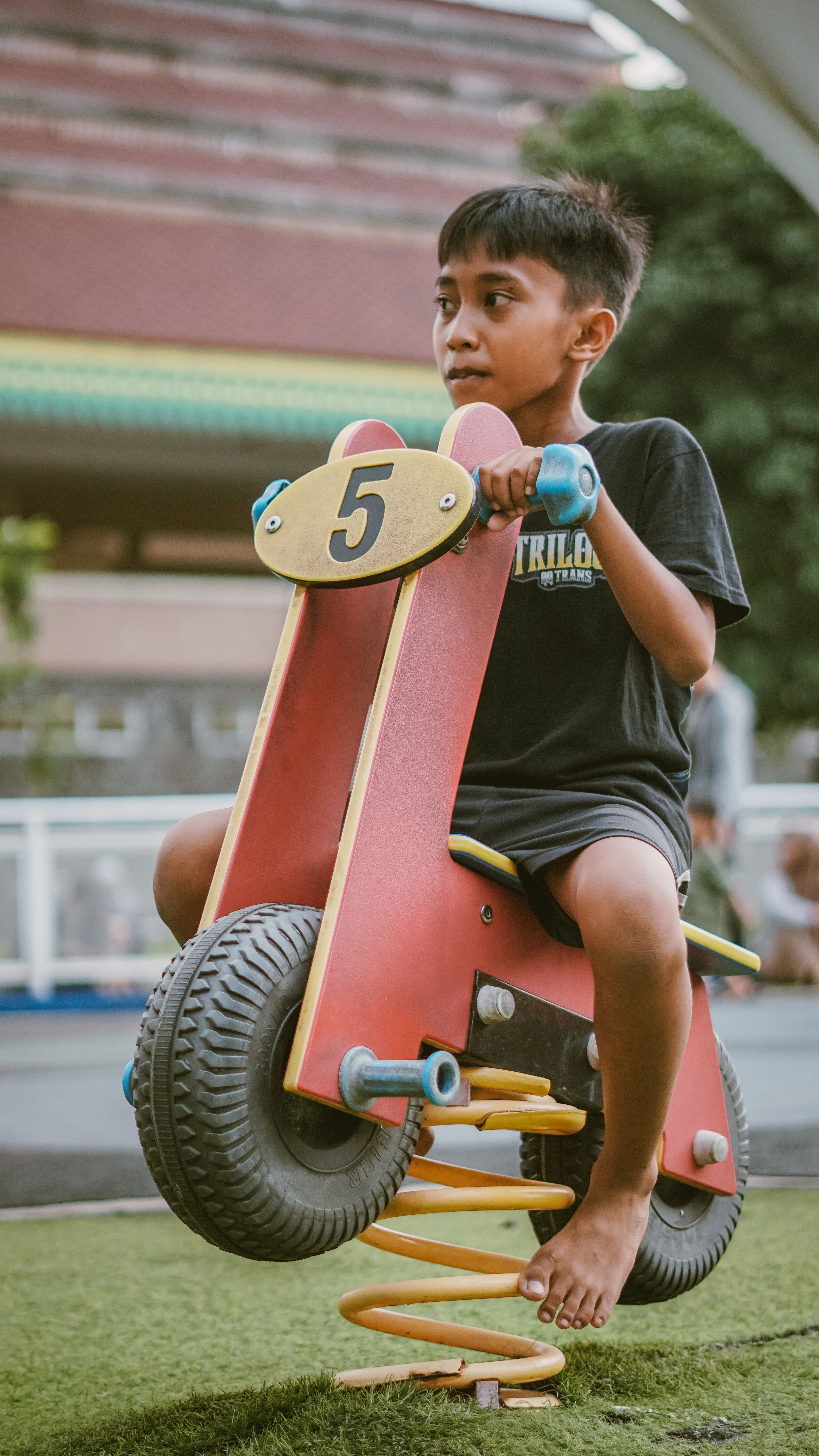 Playful Child on Spring Rider in Urban Playground · Free Stock Photo