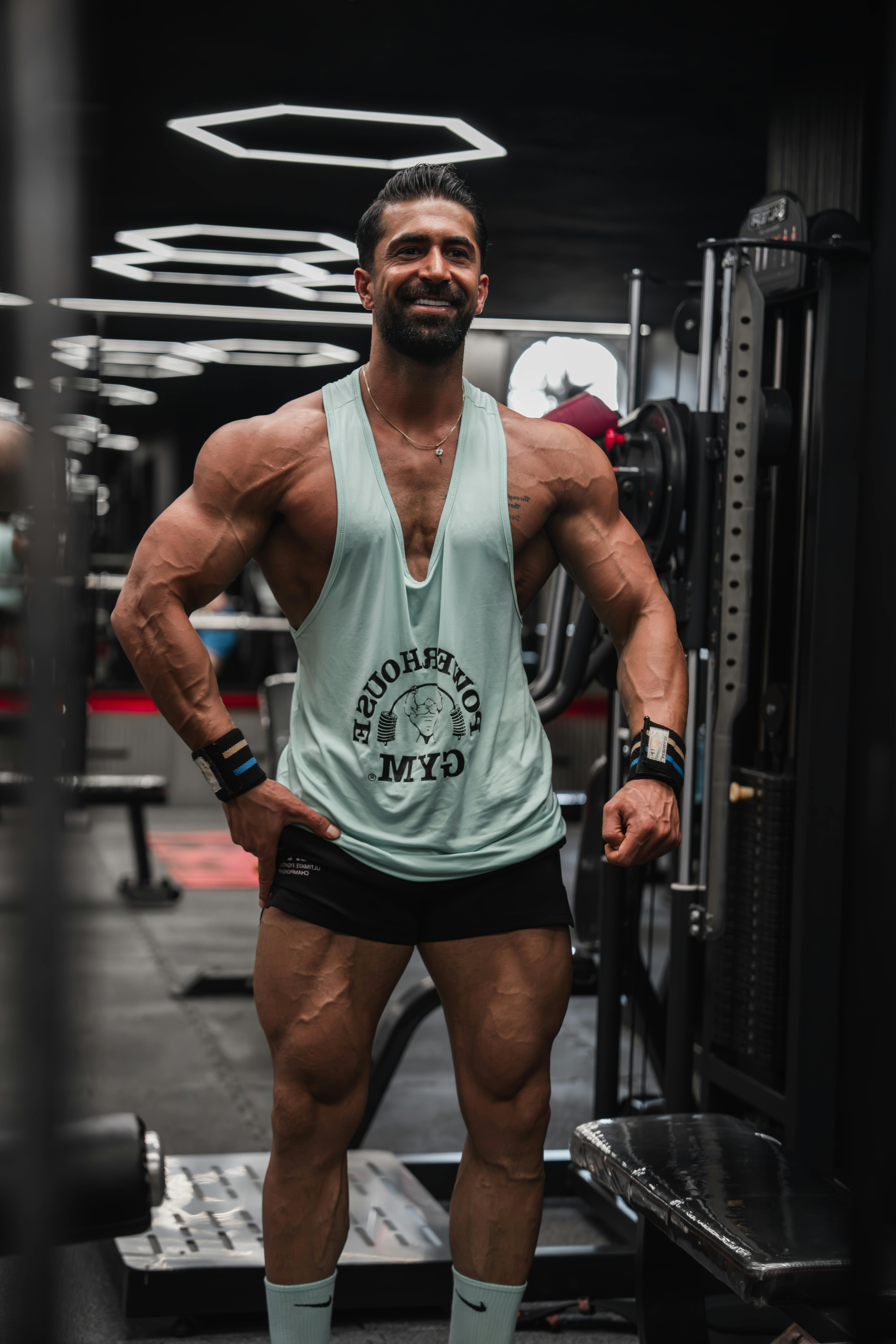 Muscular Man Posing in Gym with Equipment · Free Stock Photo