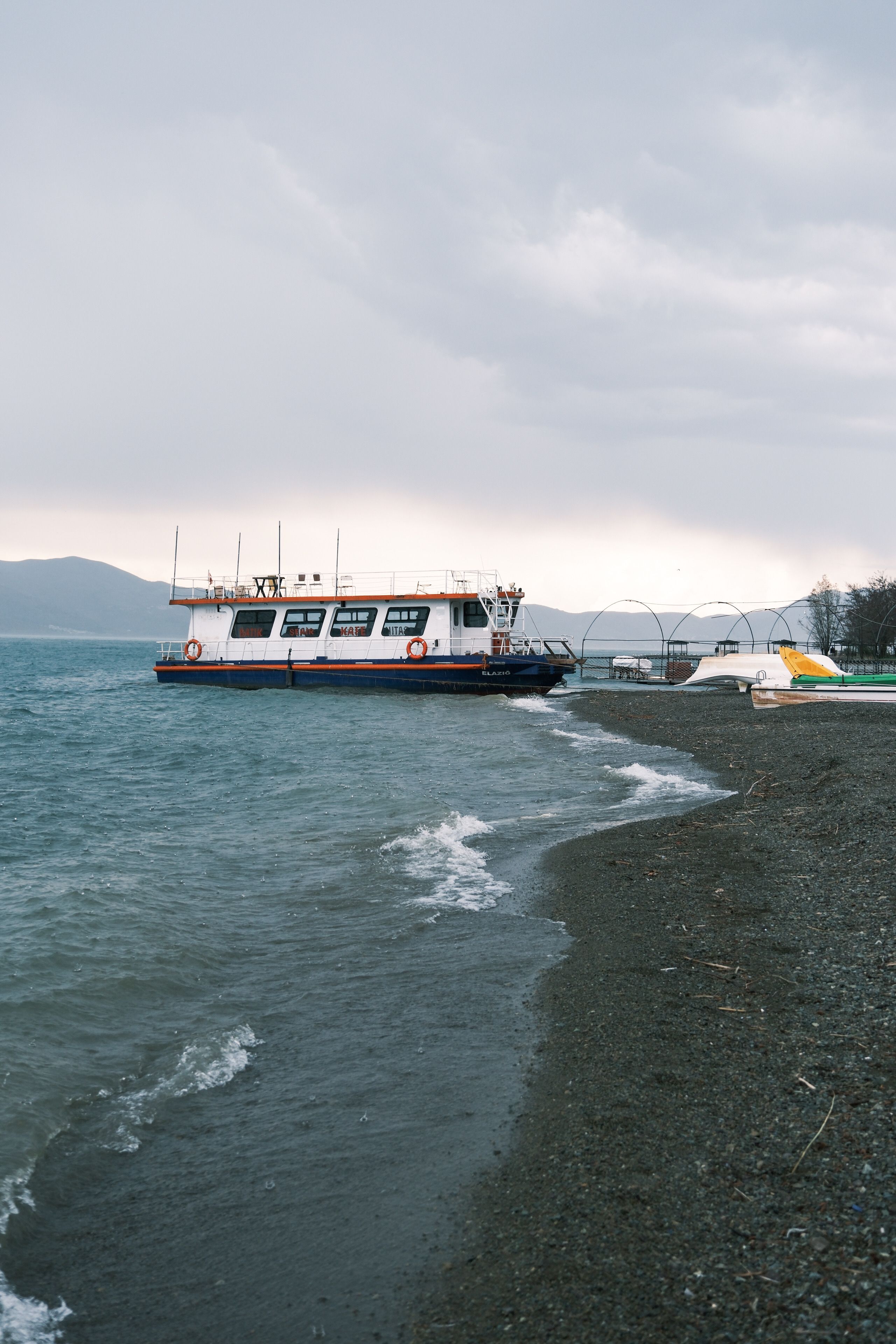 Passenger Ferry Docked at Calm Lakeshore · Free Stock Photo
