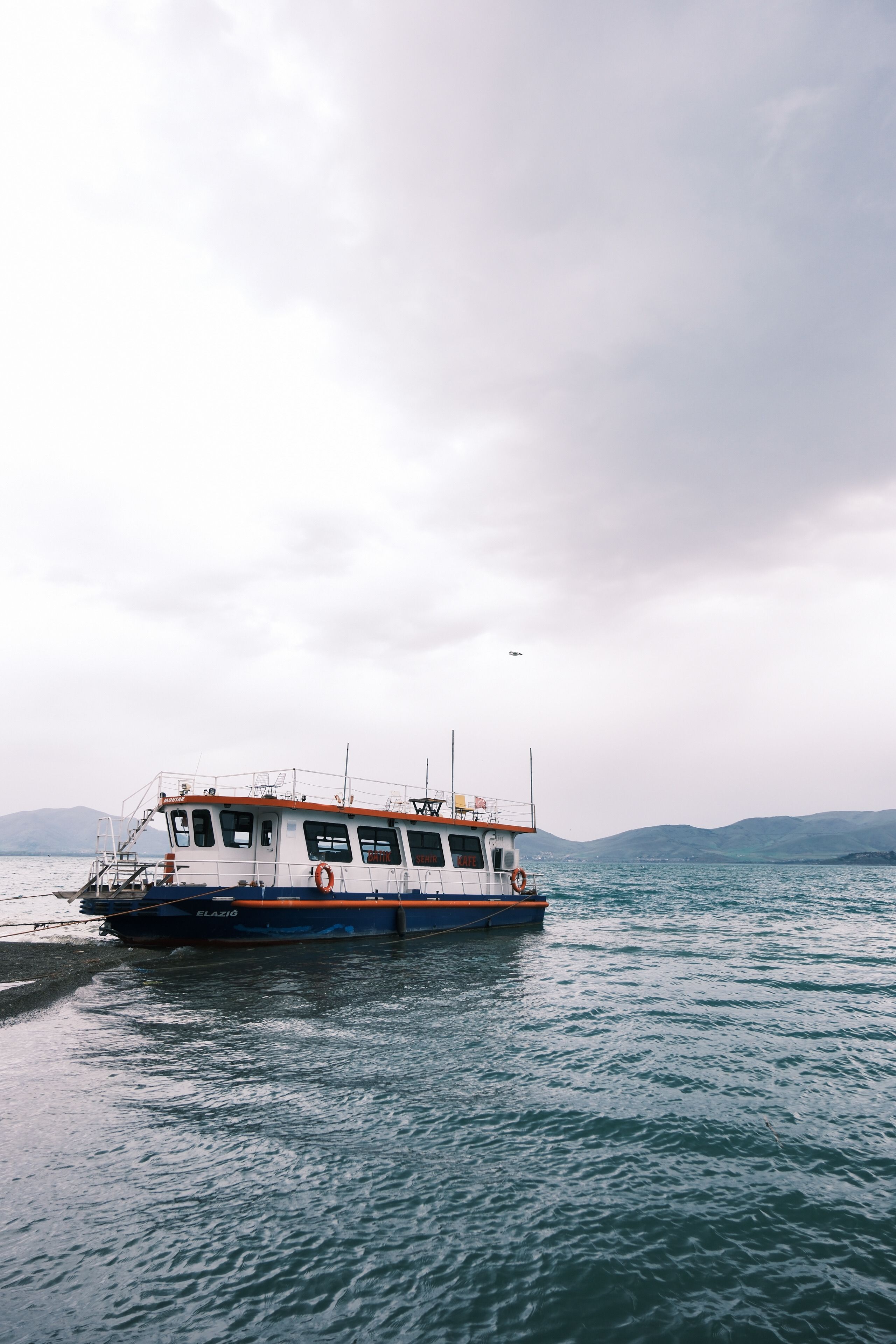 Scenic Boat on the Ocean Against Cloudy Sky · Free Stock Photo