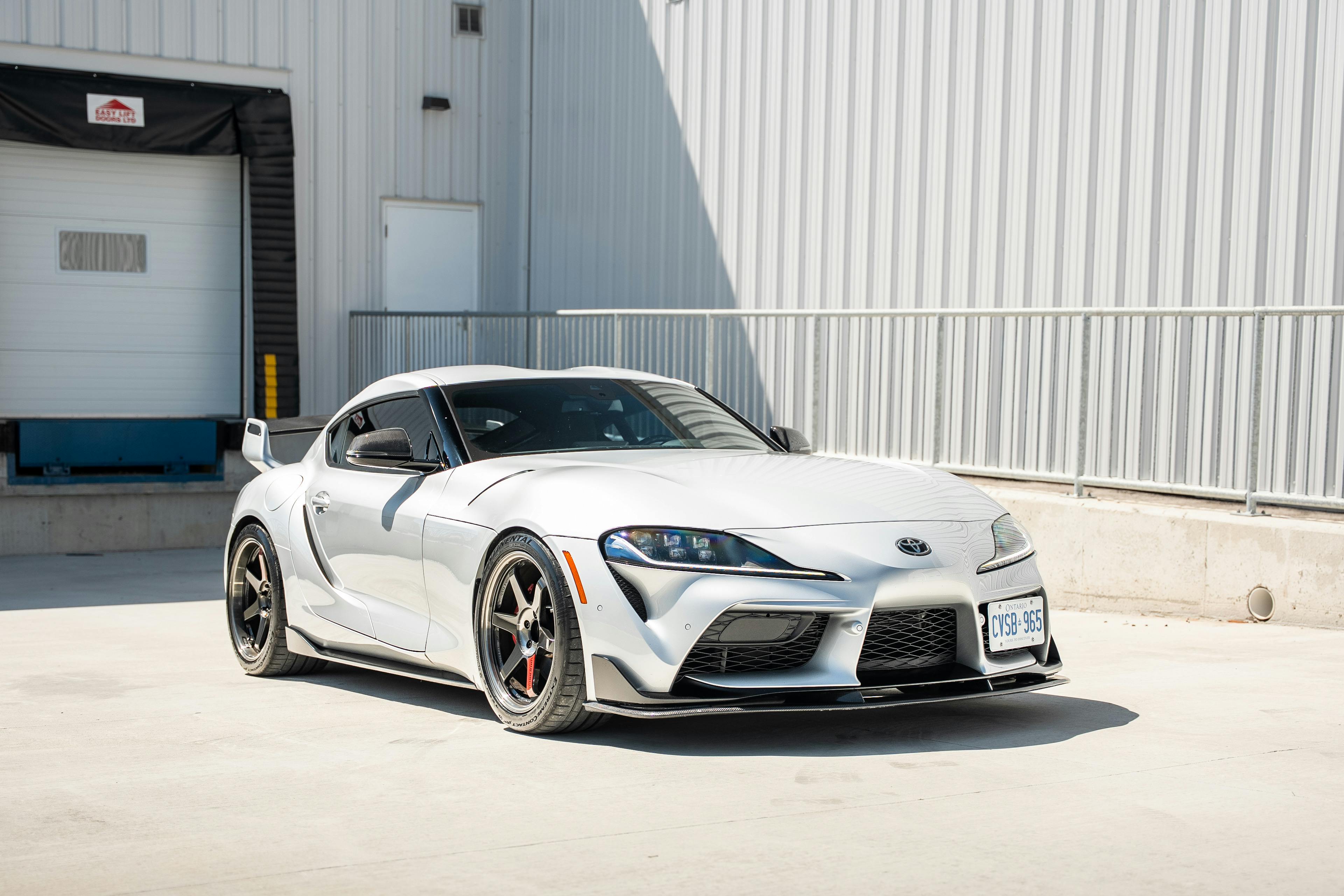 Toyota Supra Plateado En Un Entorno Industrial · Foto de stock gratuita