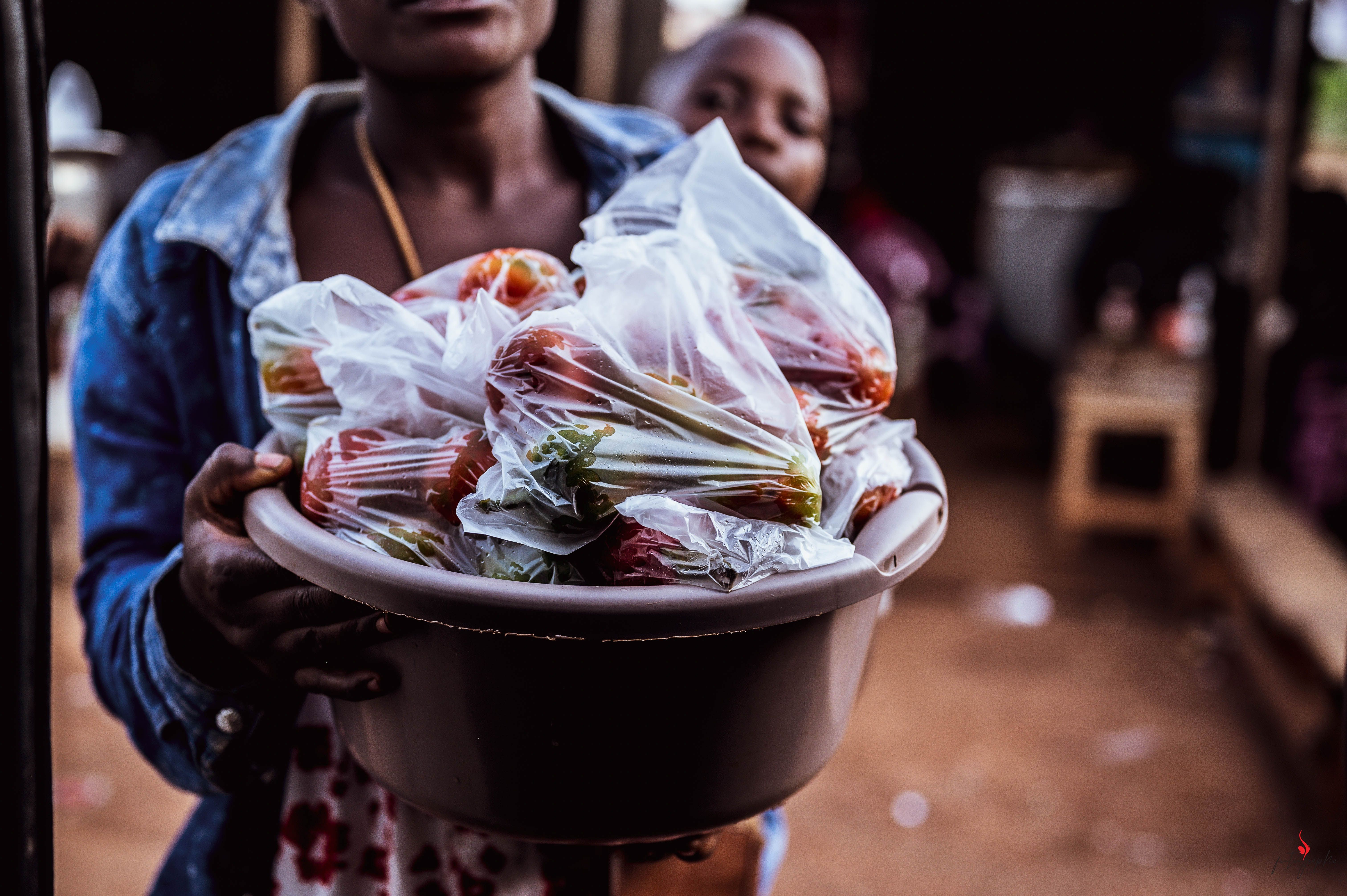 Street Vendor Holding Fresh Produce in Basin · Free Stock Photo