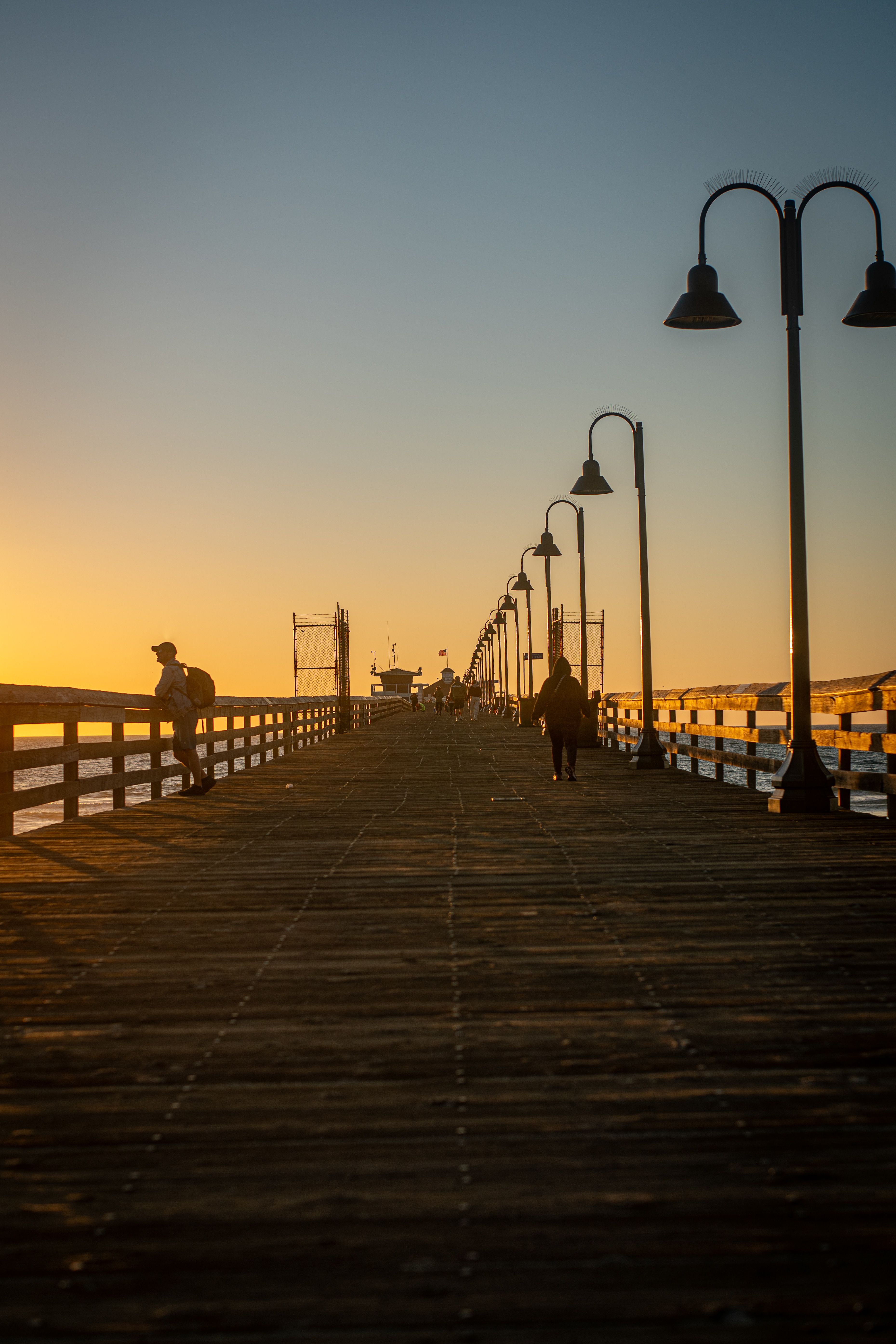 Sunset View on Ocean Pier with Street Lamps · Free Stock Photo