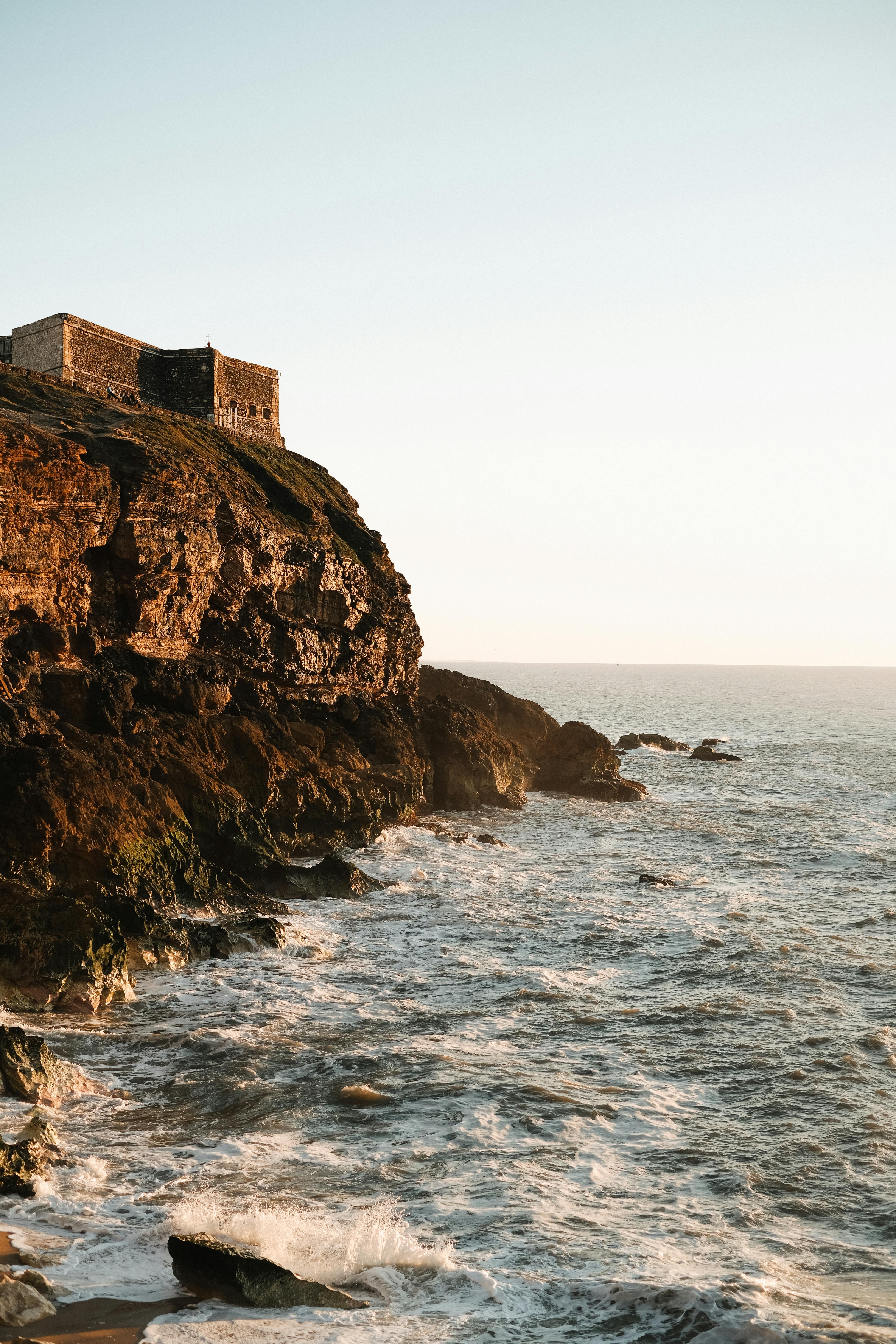Dramatic Coastal Cliffside Fortress at Sunrise · Free Stock Photo