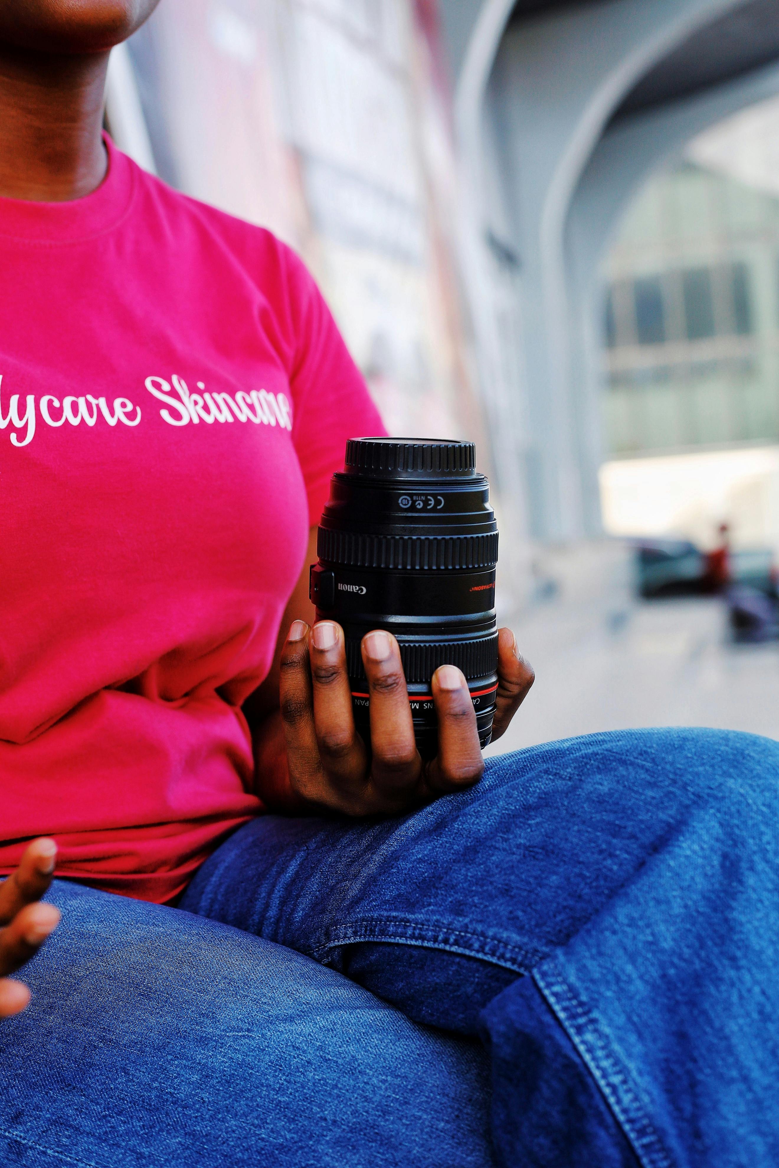 Person Holding Camera Lens in Urban Setting · Free Stock Photo