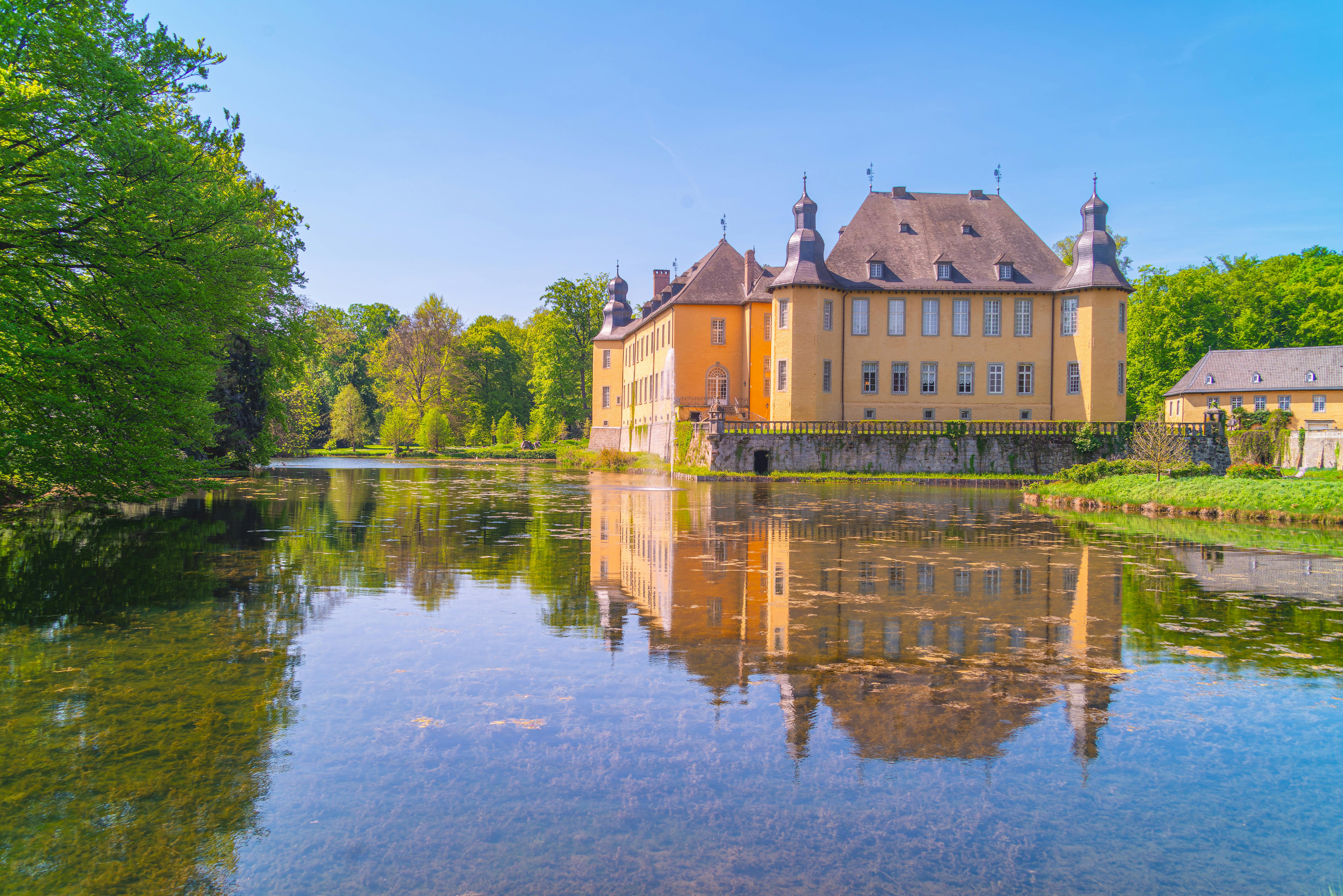 Historic German Castle Reflecting in Moat · Free Stock Photo