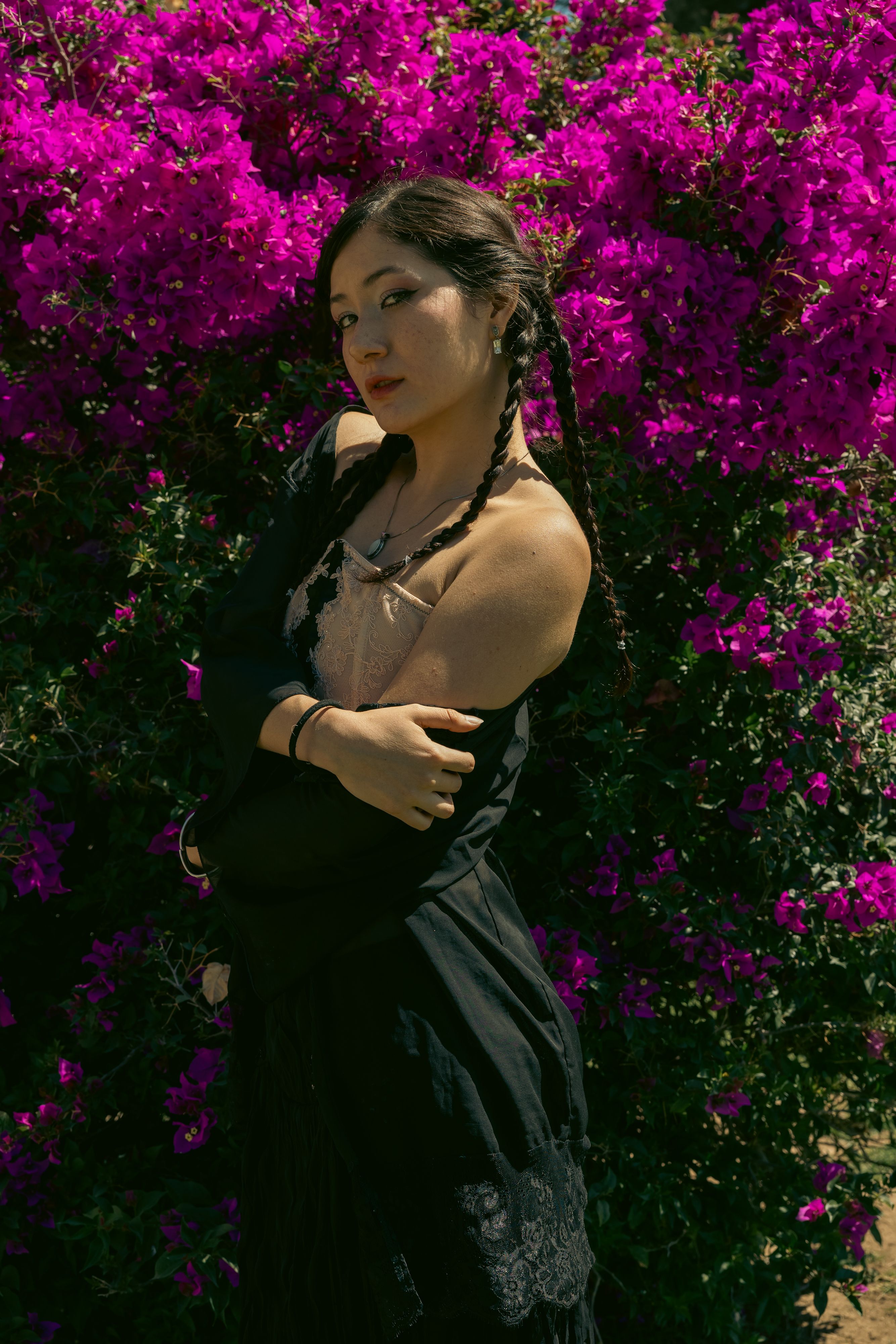 Woman in Black Dress with Vibrant Purple Flowers · Free Stock Photo