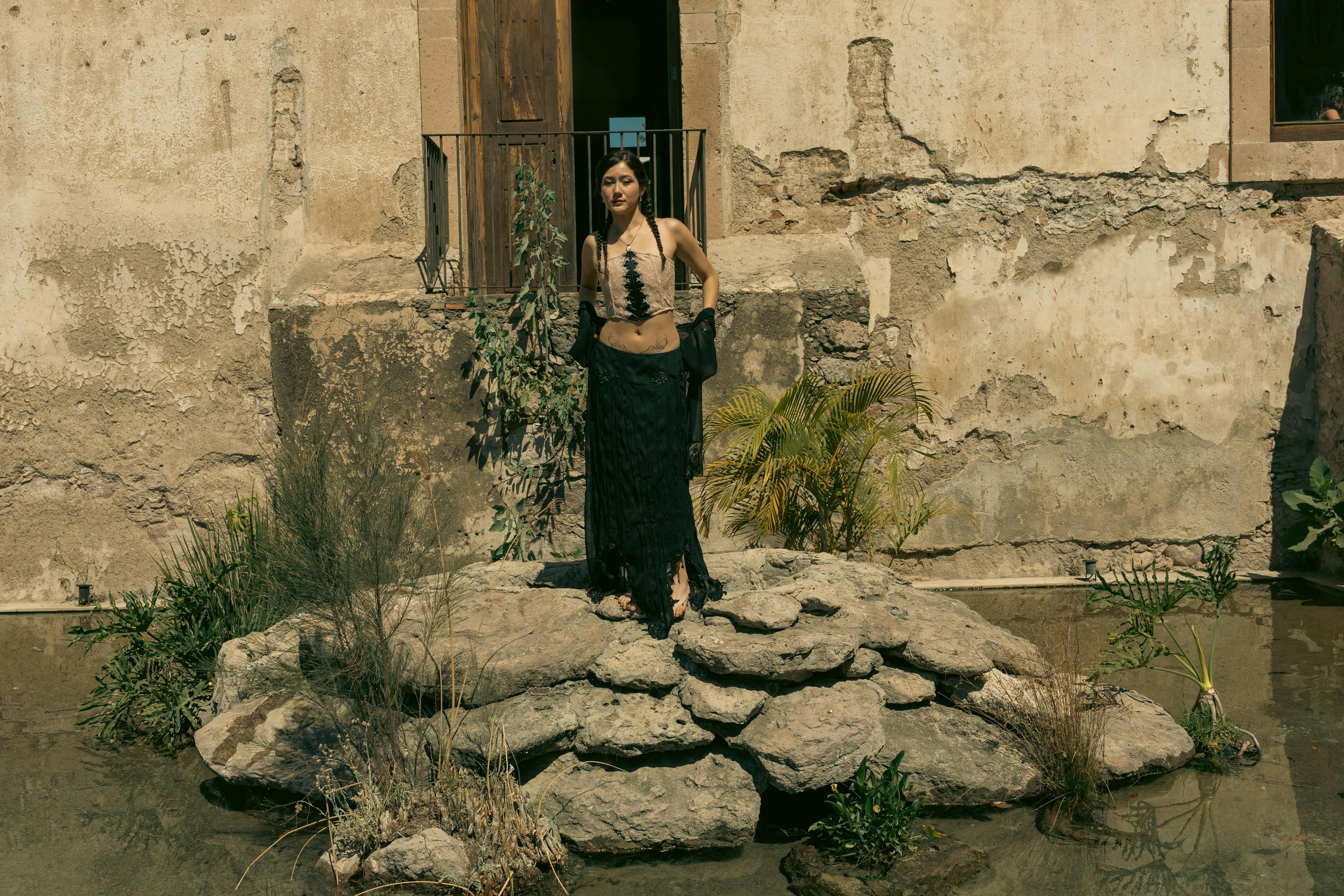 Woman in Eclectic Outfit Standing on Rocks · Free Stock Photo