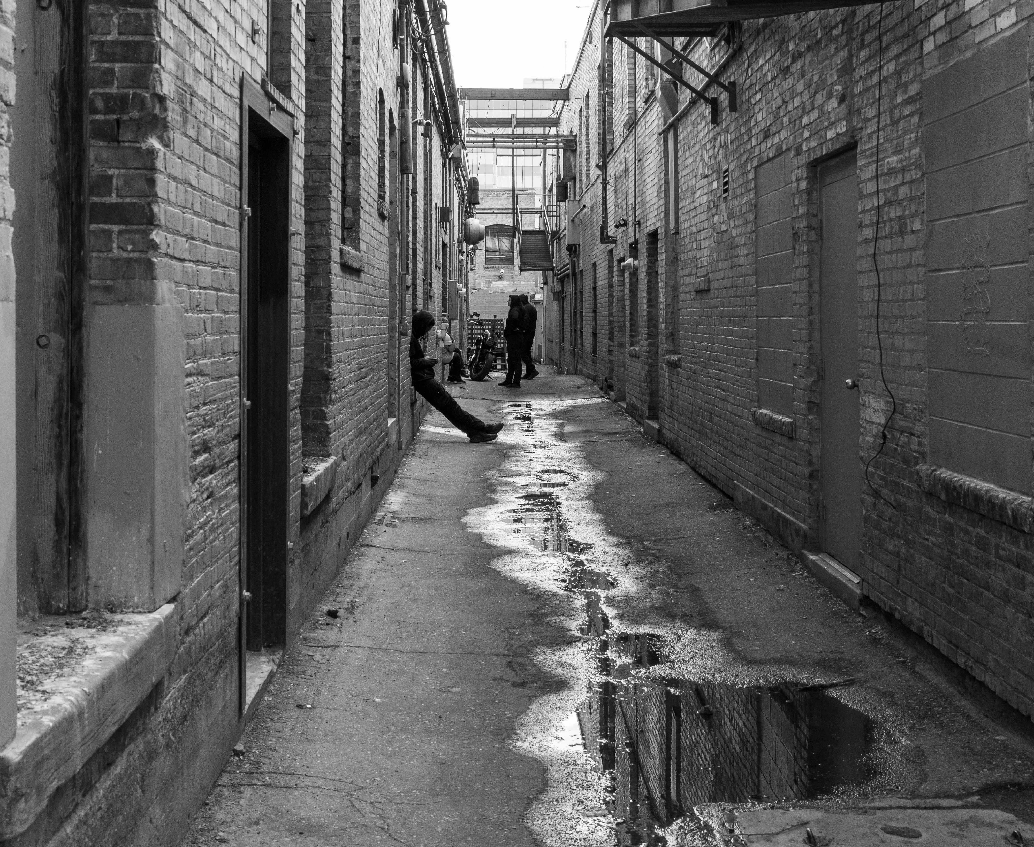 Moody Black and White Alley Scene with Puddles · Free Stock Photo