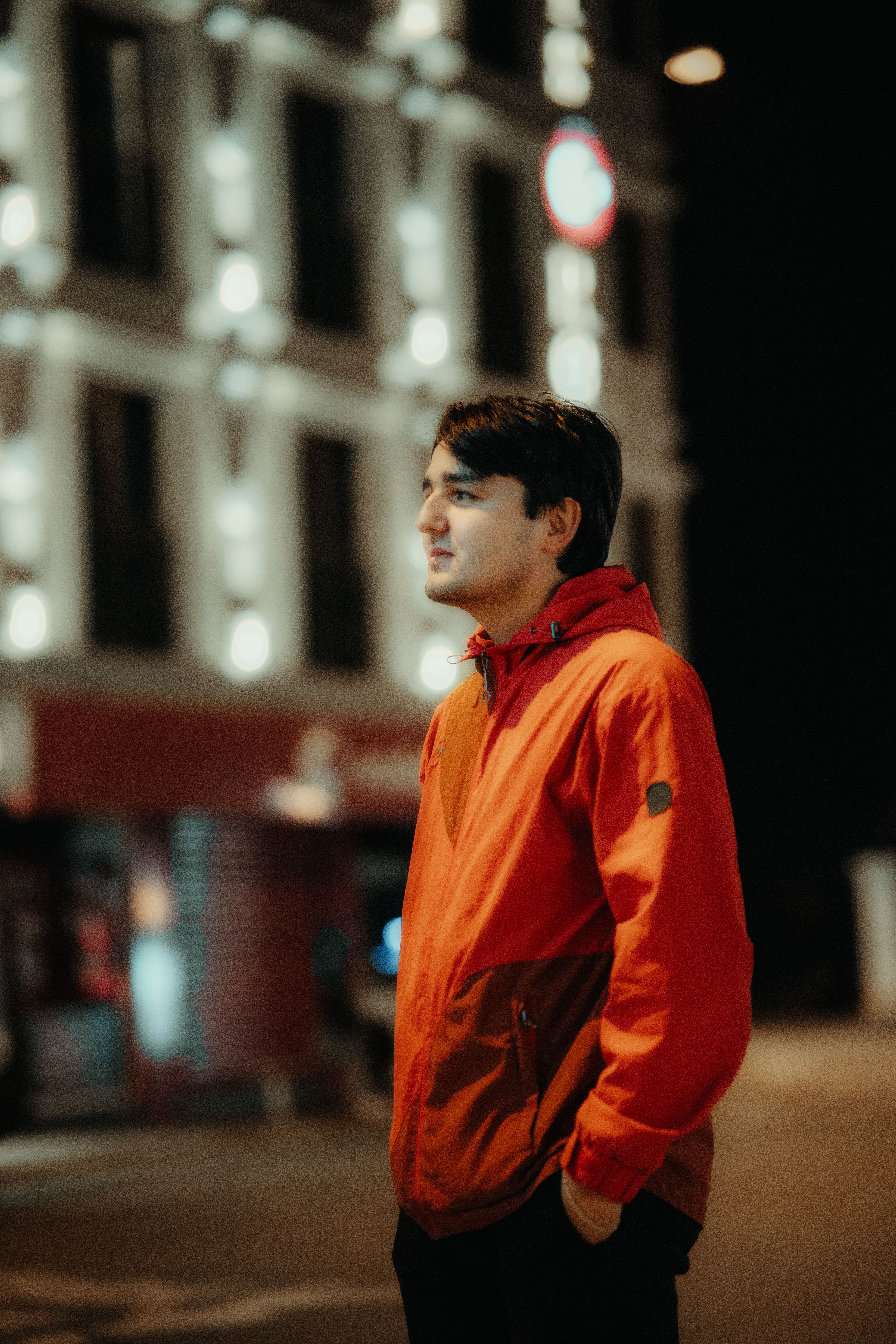 Young Man in Red Jacket at Night Cityscape · Free Stock Photo