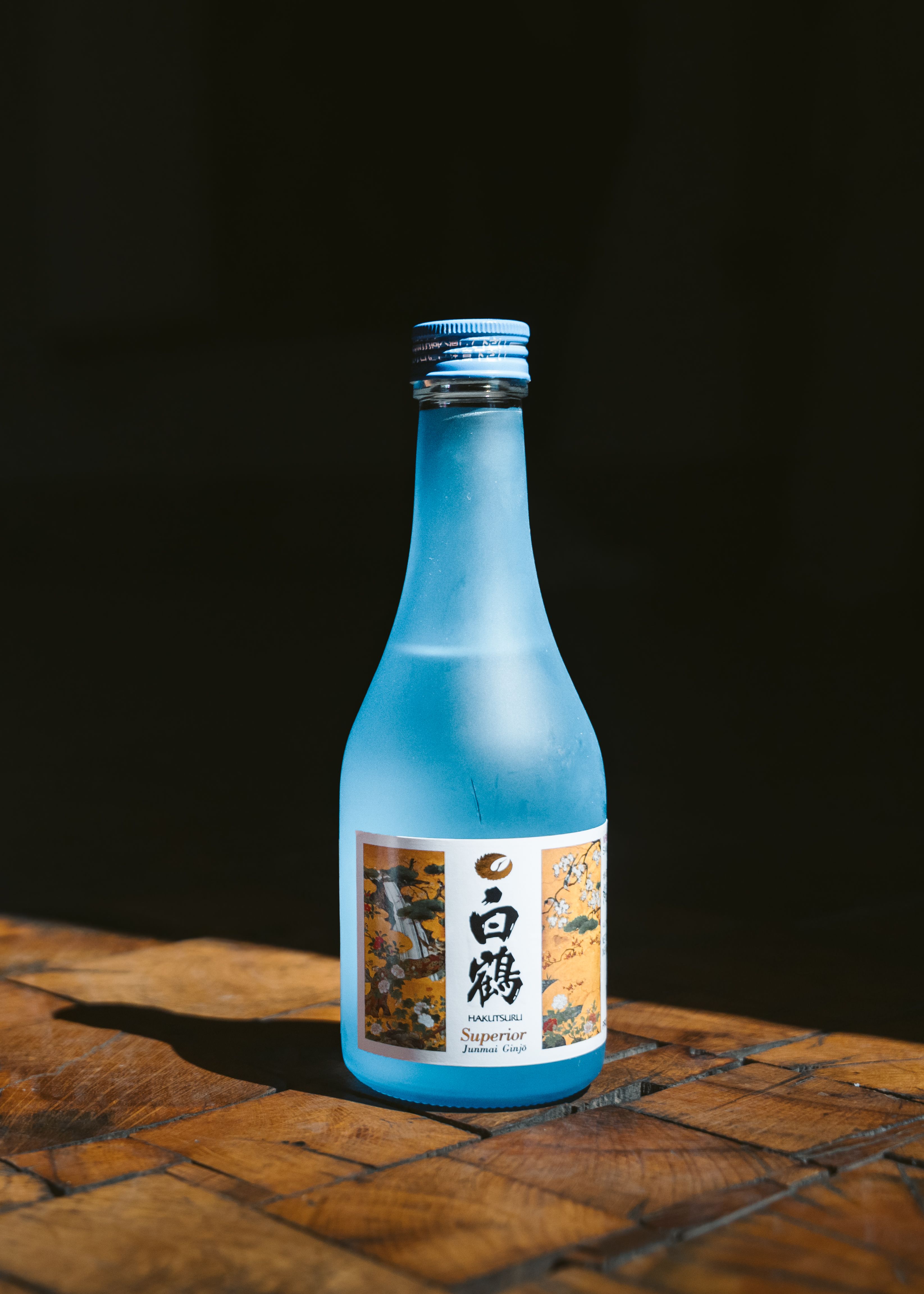 Minimalist Blue Sake Bottle on Wooden Table · Free Stock Photo