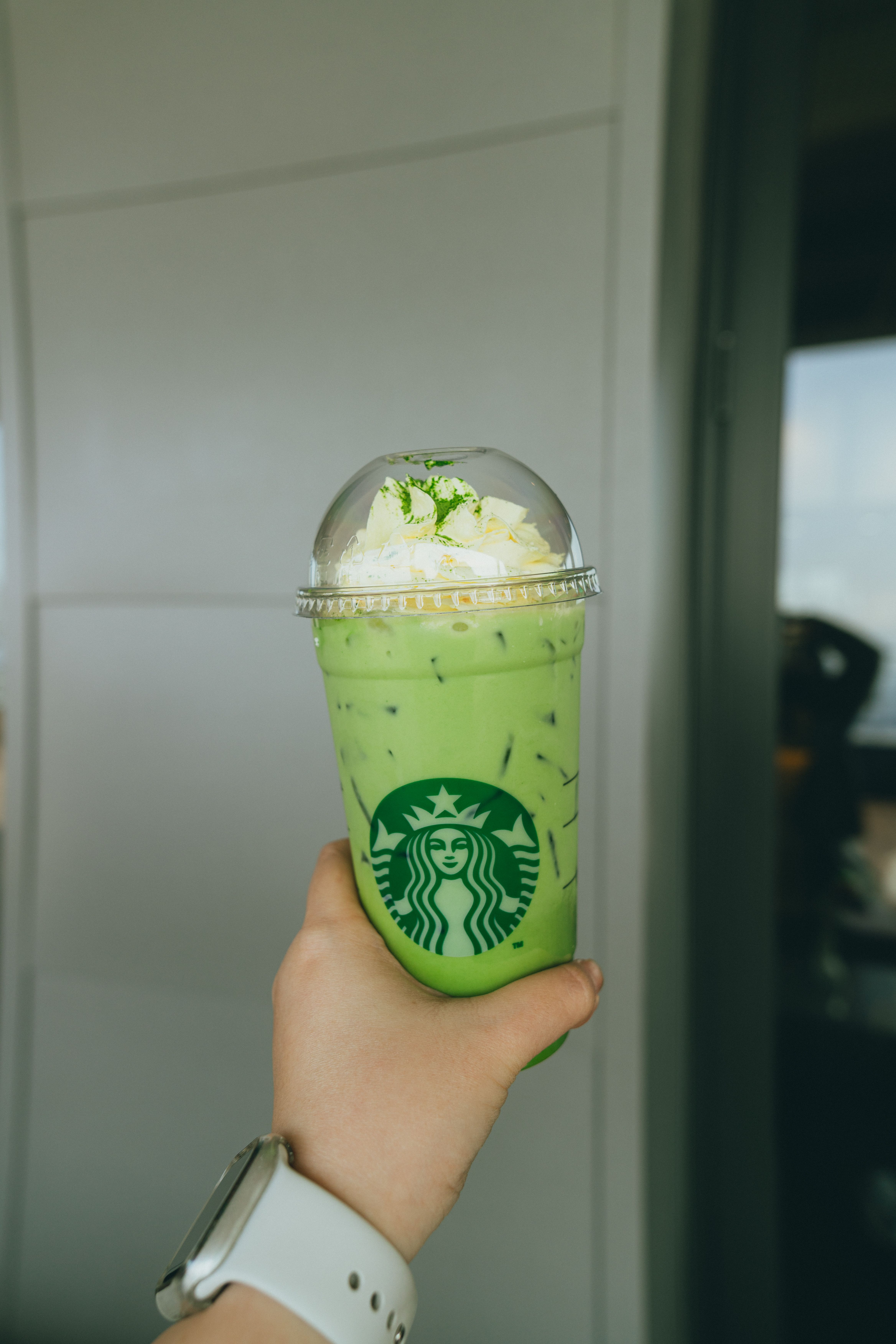 Refreshing Iced Matcha Latte in Hand at Cafe · Free Stock Photo