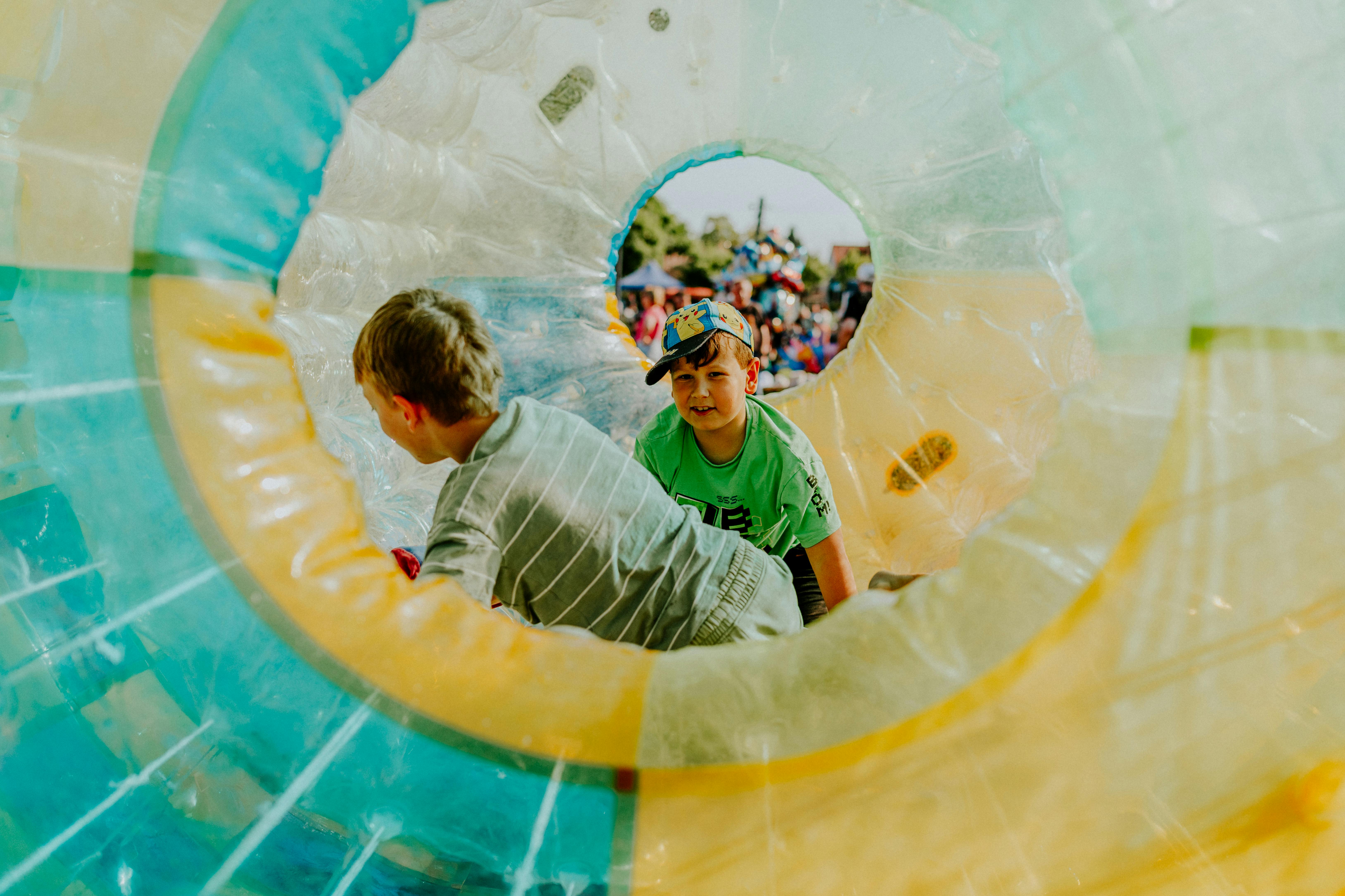 Children Playing Inside Inflatable Zorb Ball Outdoors · Free Stock Photo
