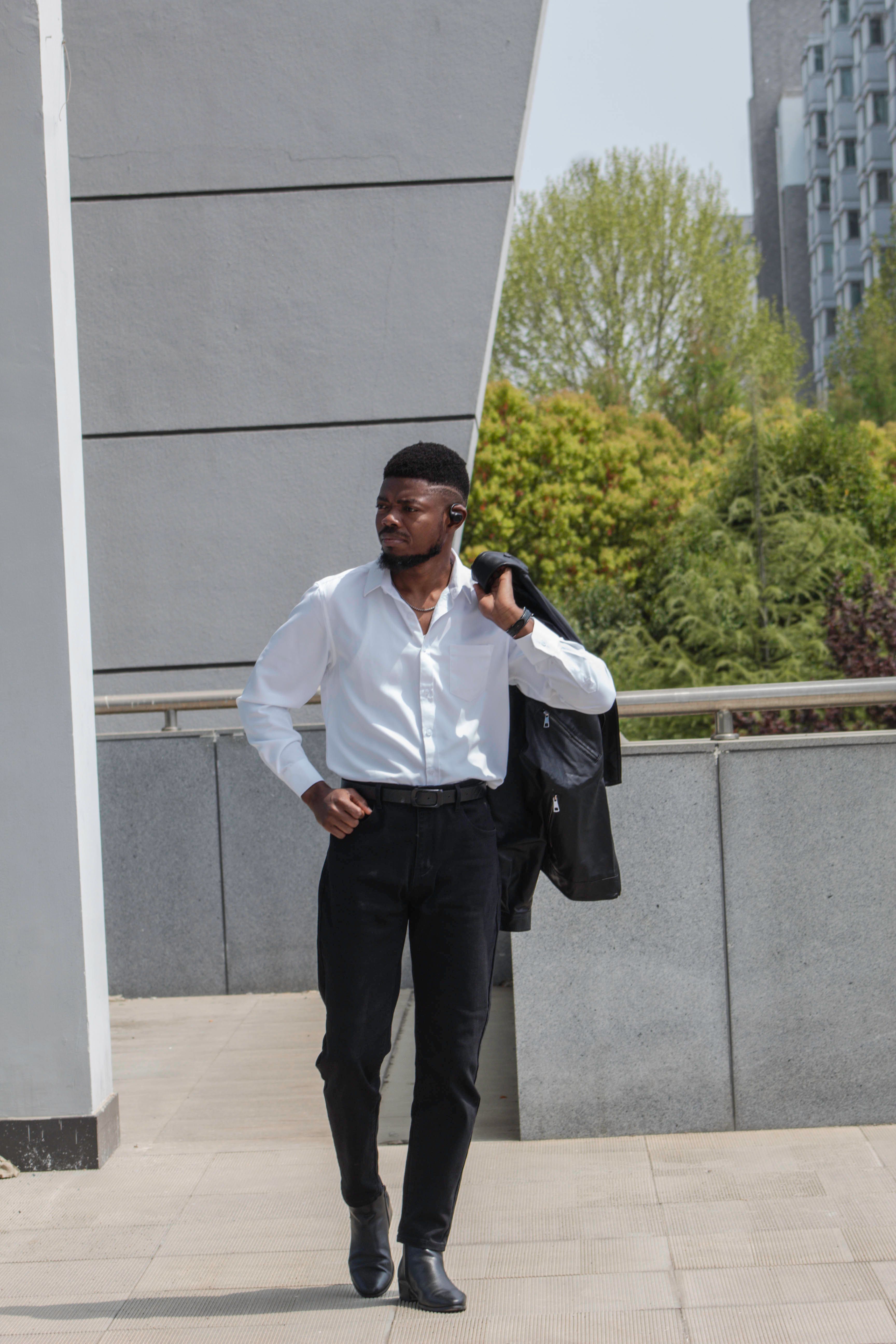 Confident Man Walking Outdoors in Urban Setting · Free Stock Photo