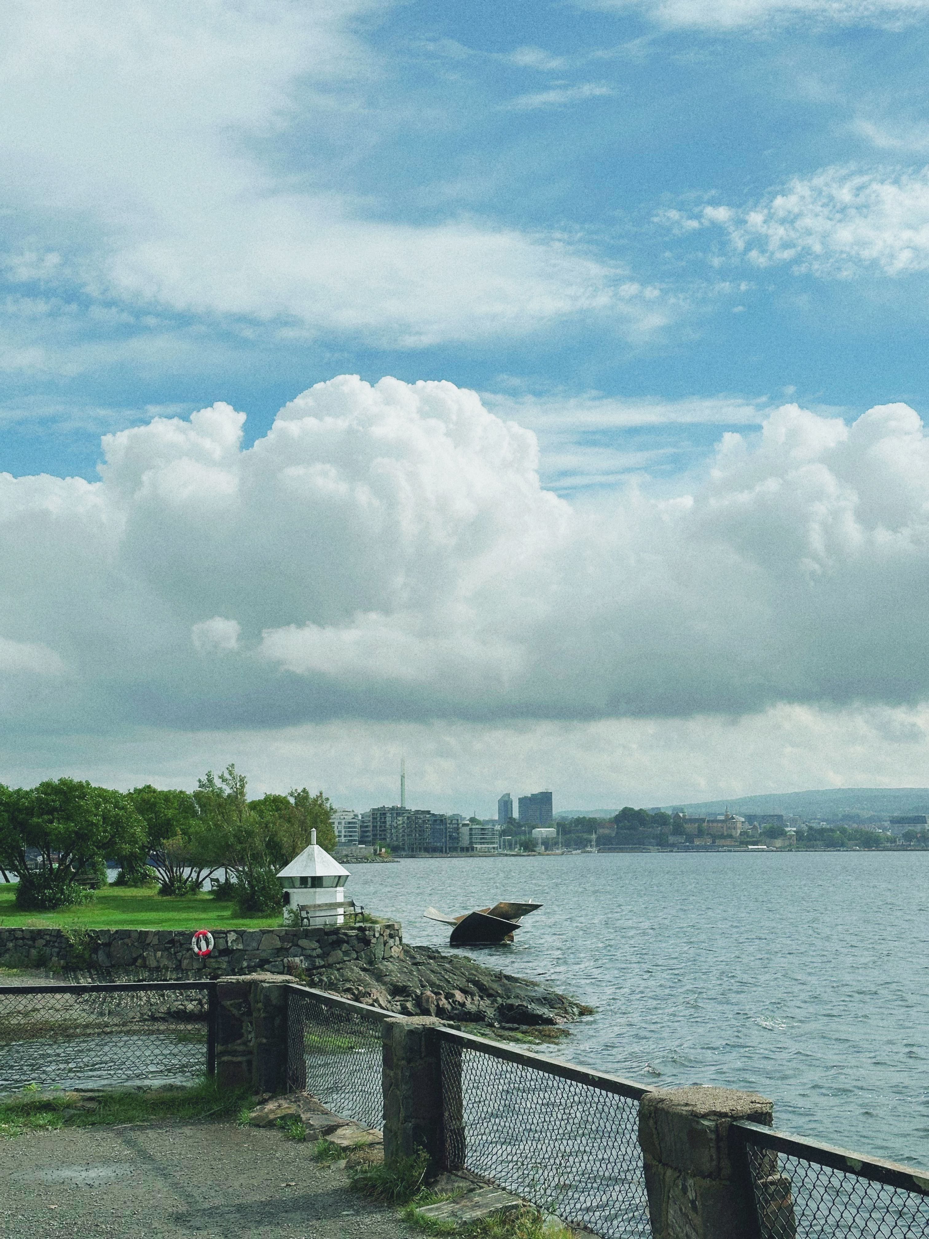 Scenic Waterfront with Cloudy Sky and City Views · Free Stock Photo