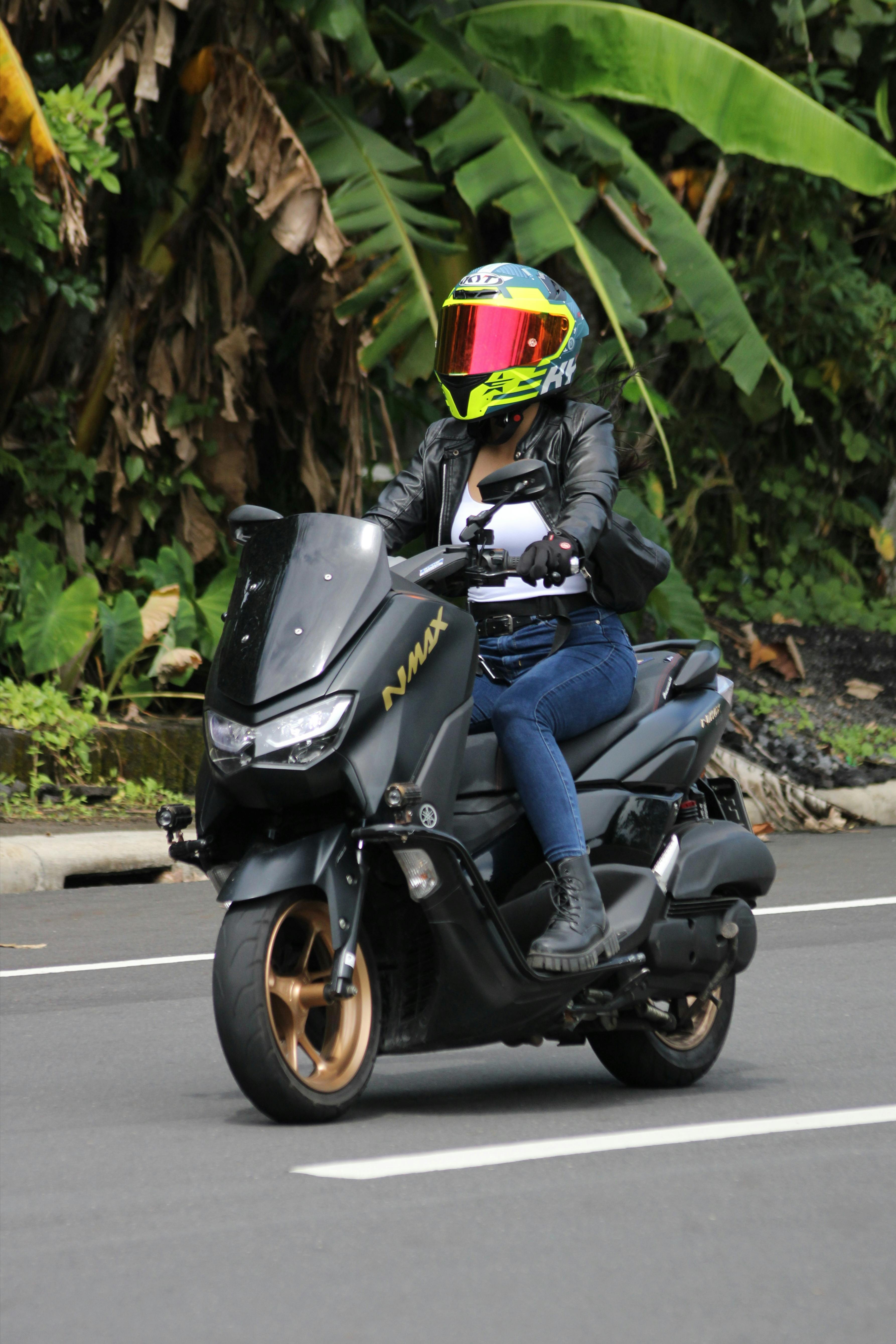 Person Riding on Yellow Motor Scooter on Road · Free Stock Photo