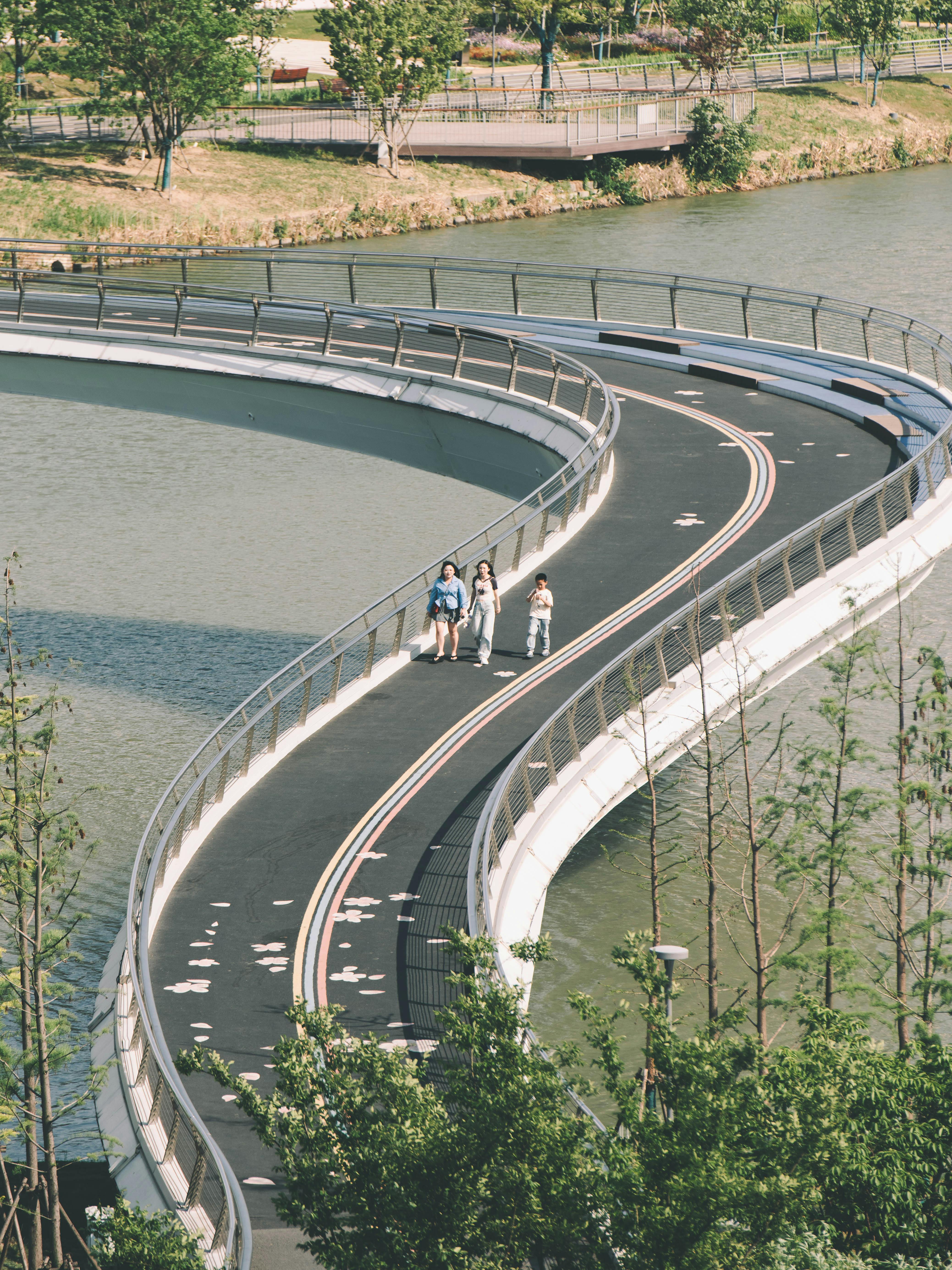 Curved Pedestrian Bridge Over Tranquil River · Free Stock Photo