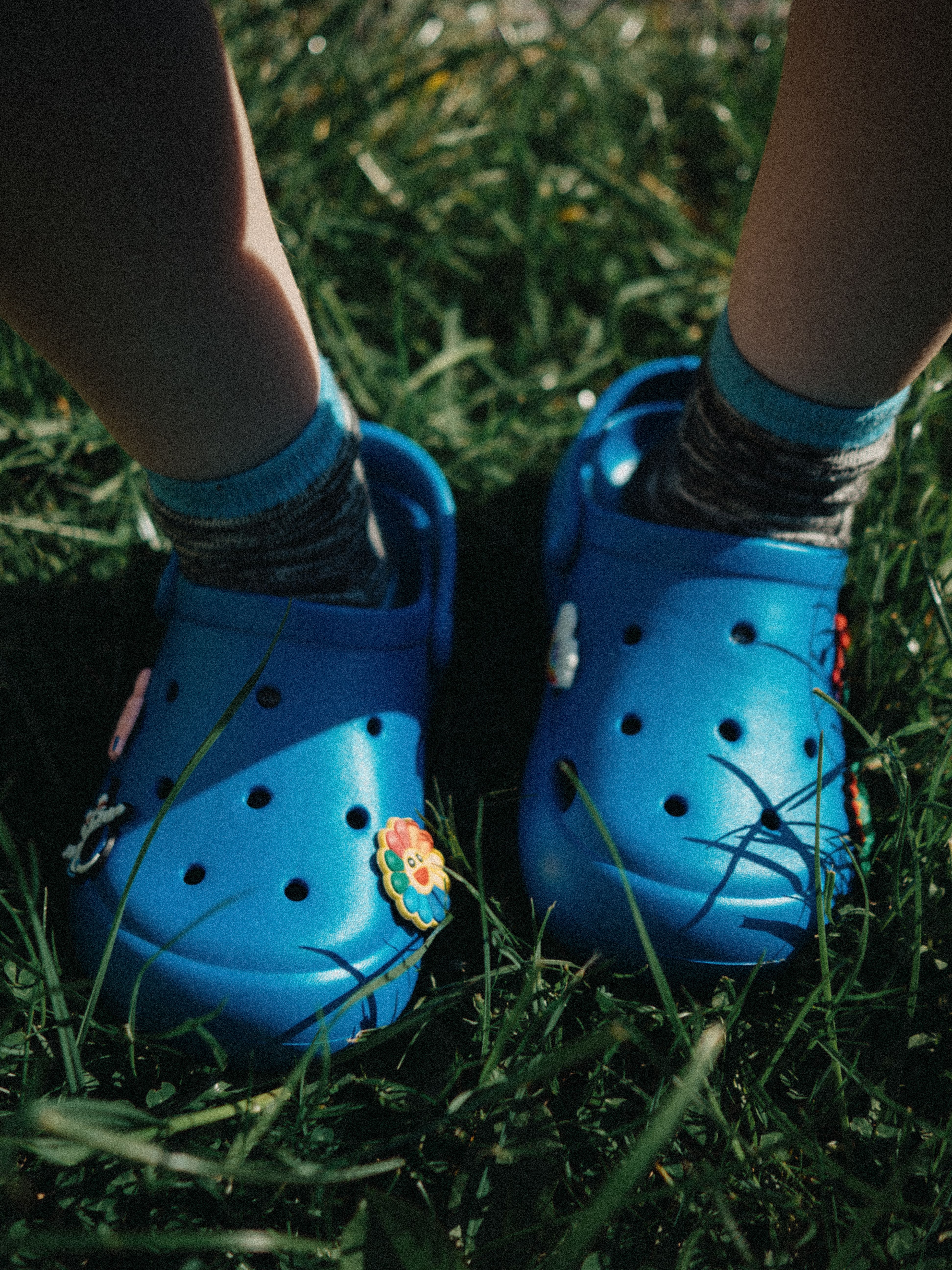 Child Wearing Blue Crocs on Grass Outdoors · Free Stock Photo