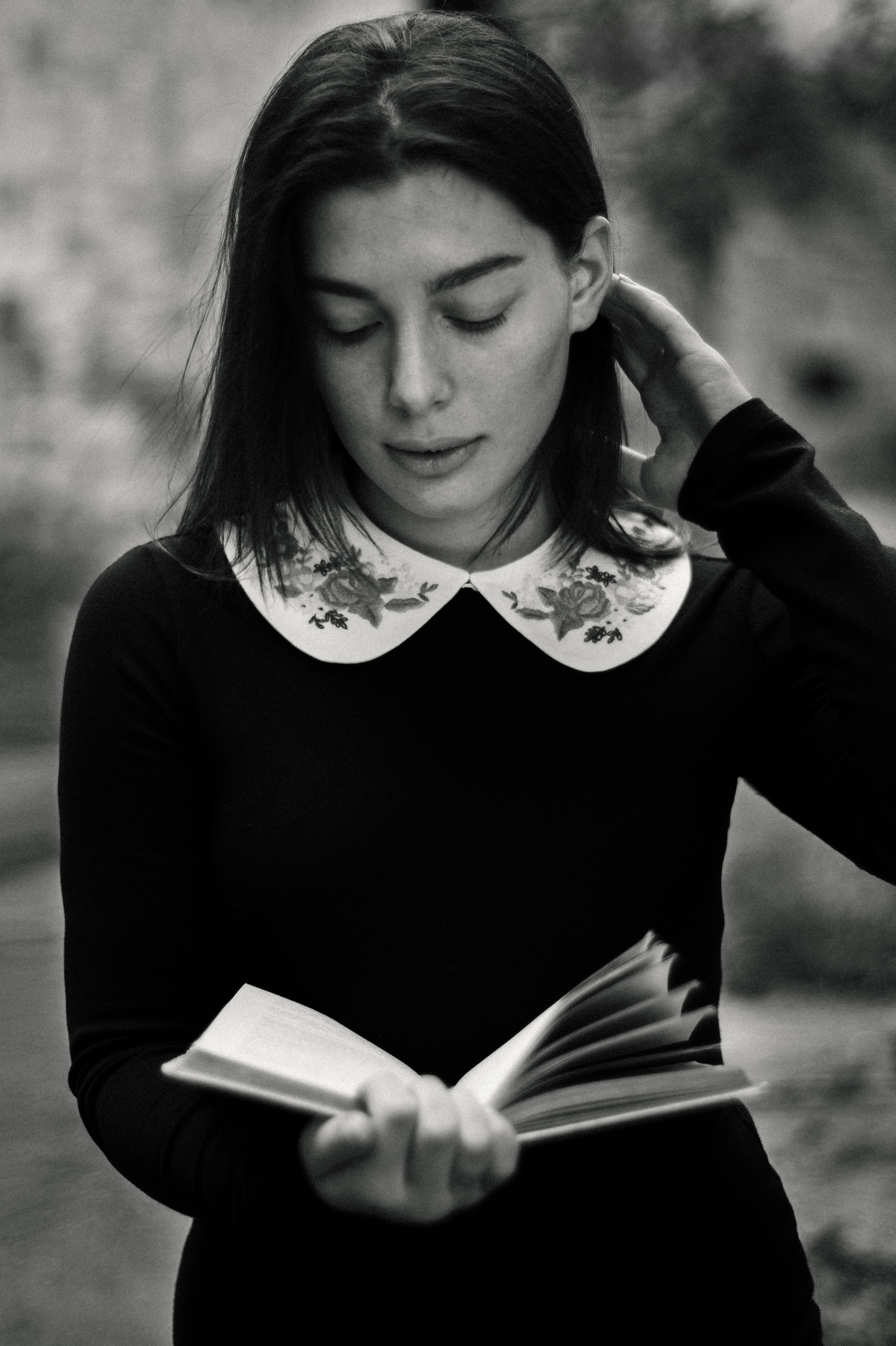 Monochrome Portrait of a Young Woman Reading Outdoors · Free Stock Photo